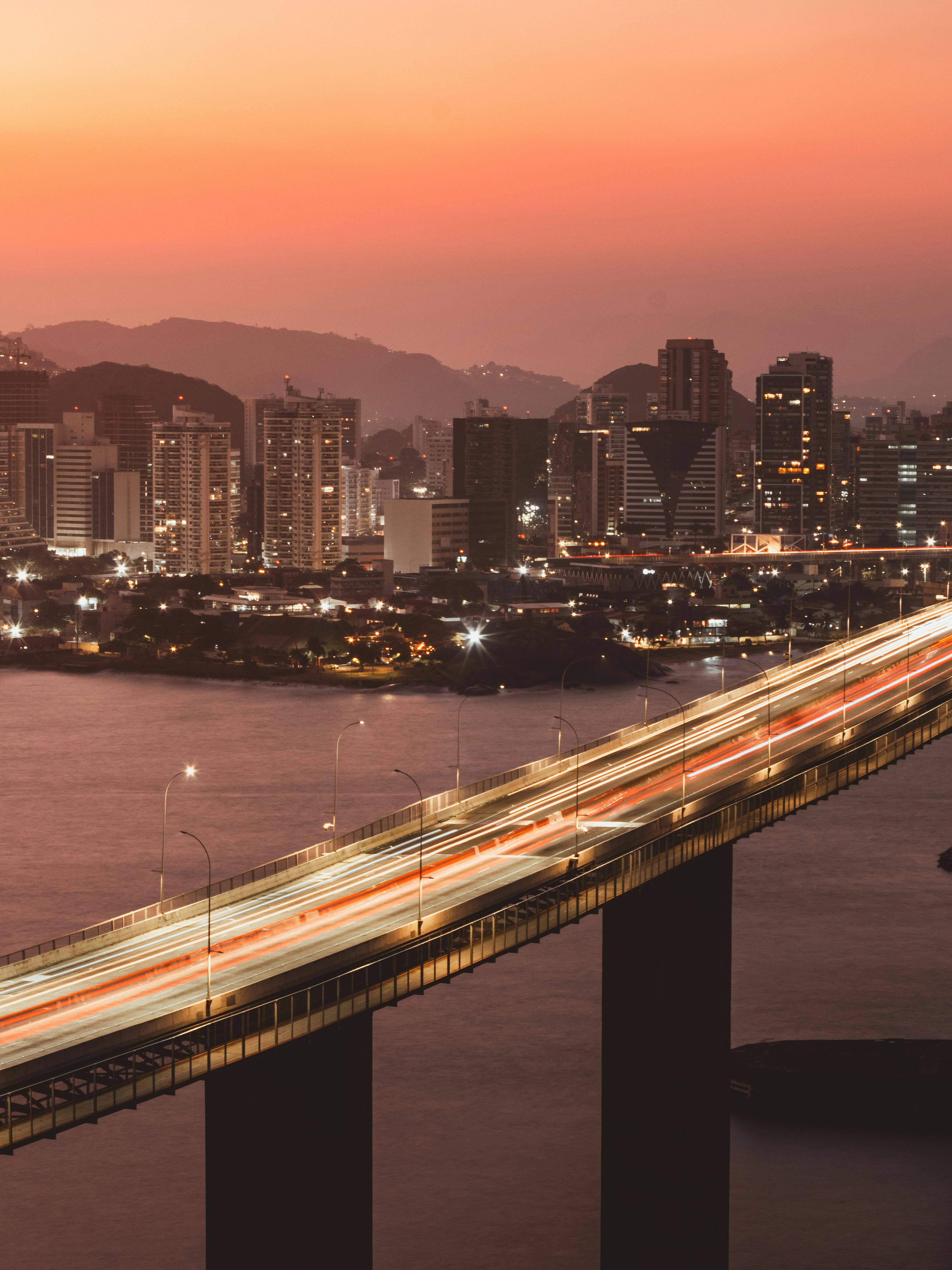 A bridge over a city at sunset with cars driving · Free Stock Photo