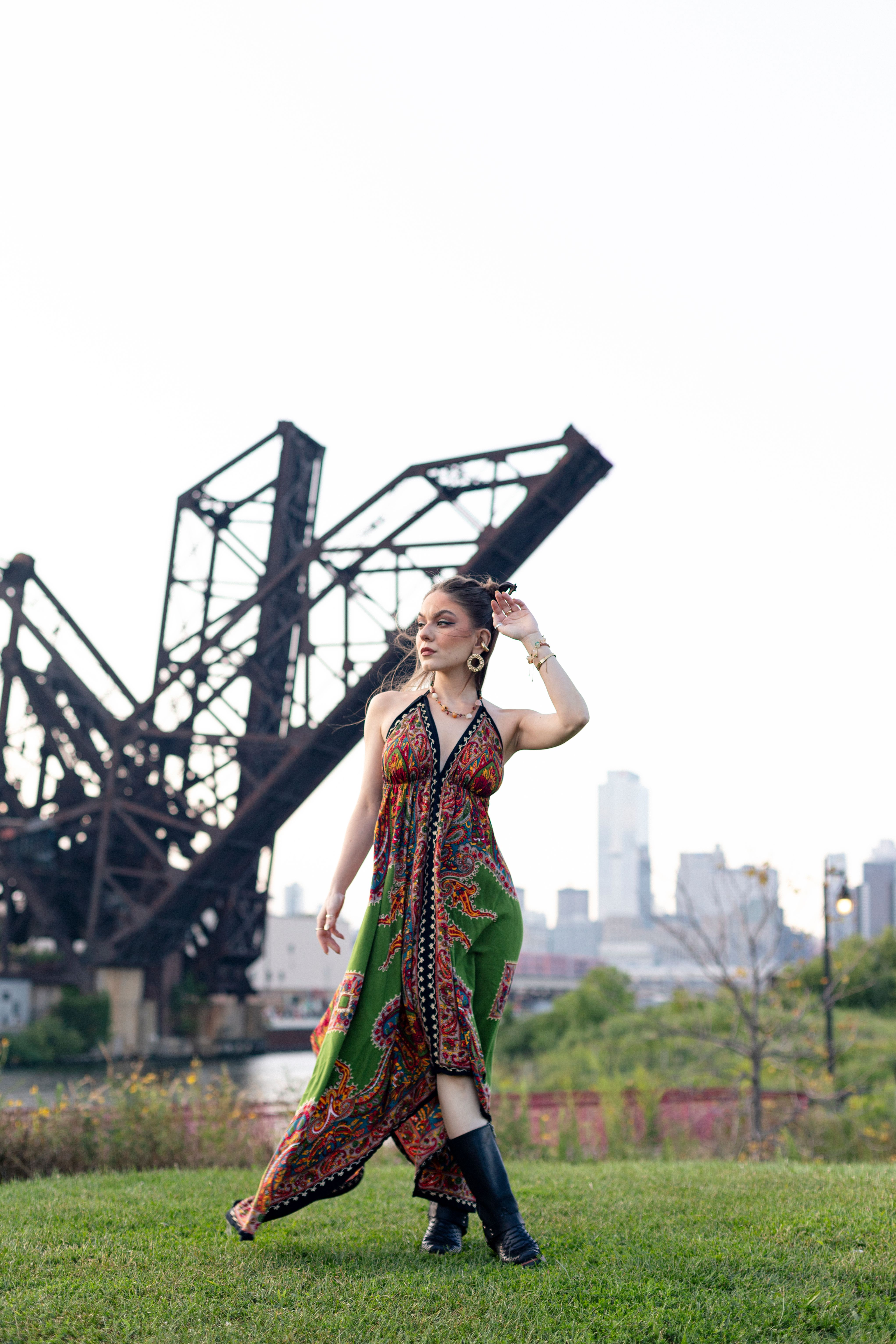 A woman in a dress and boots standing in front of a bridge · Free Stock ...
