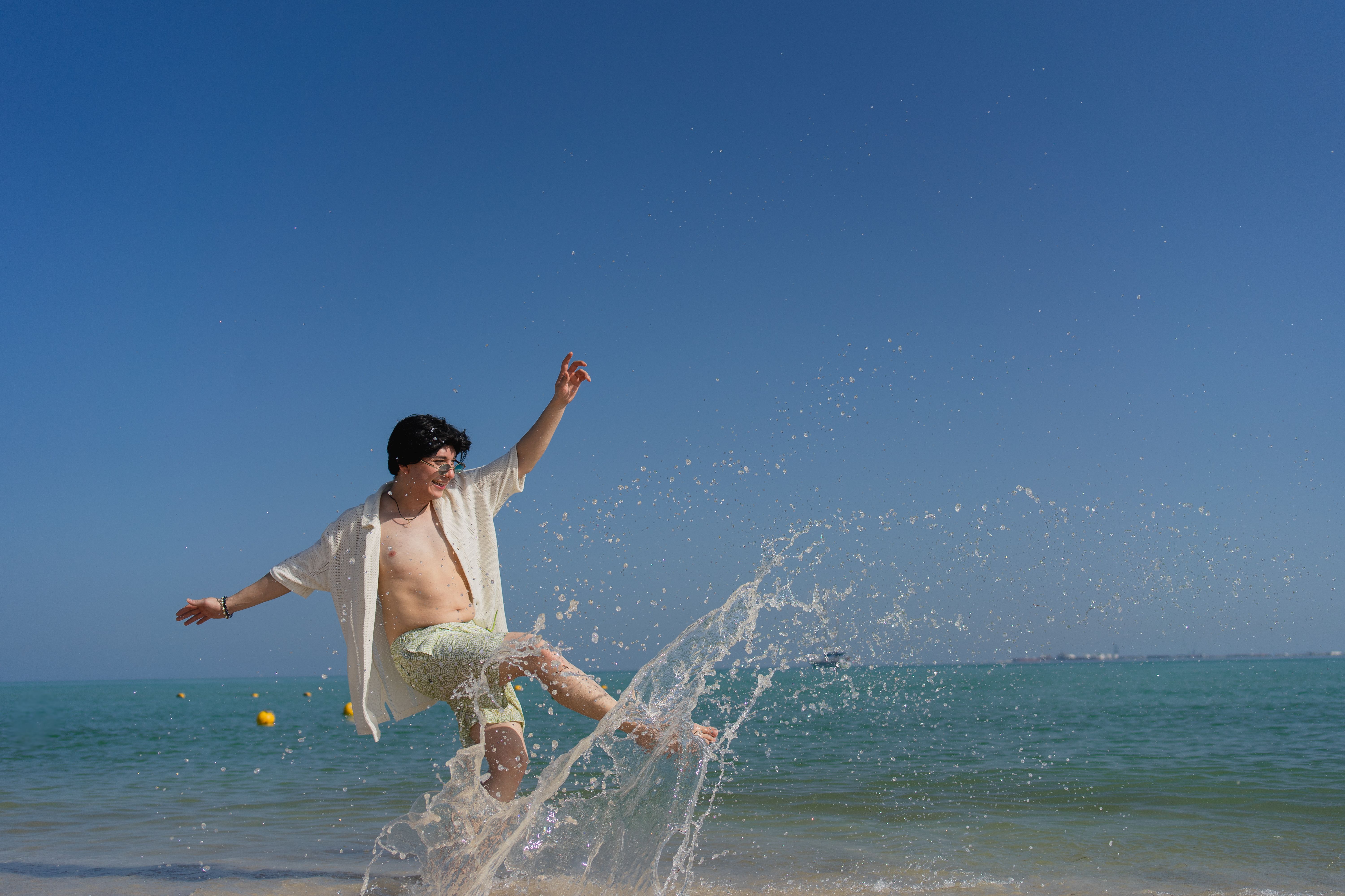 A man splashing water on the beach · Free Stock Photo