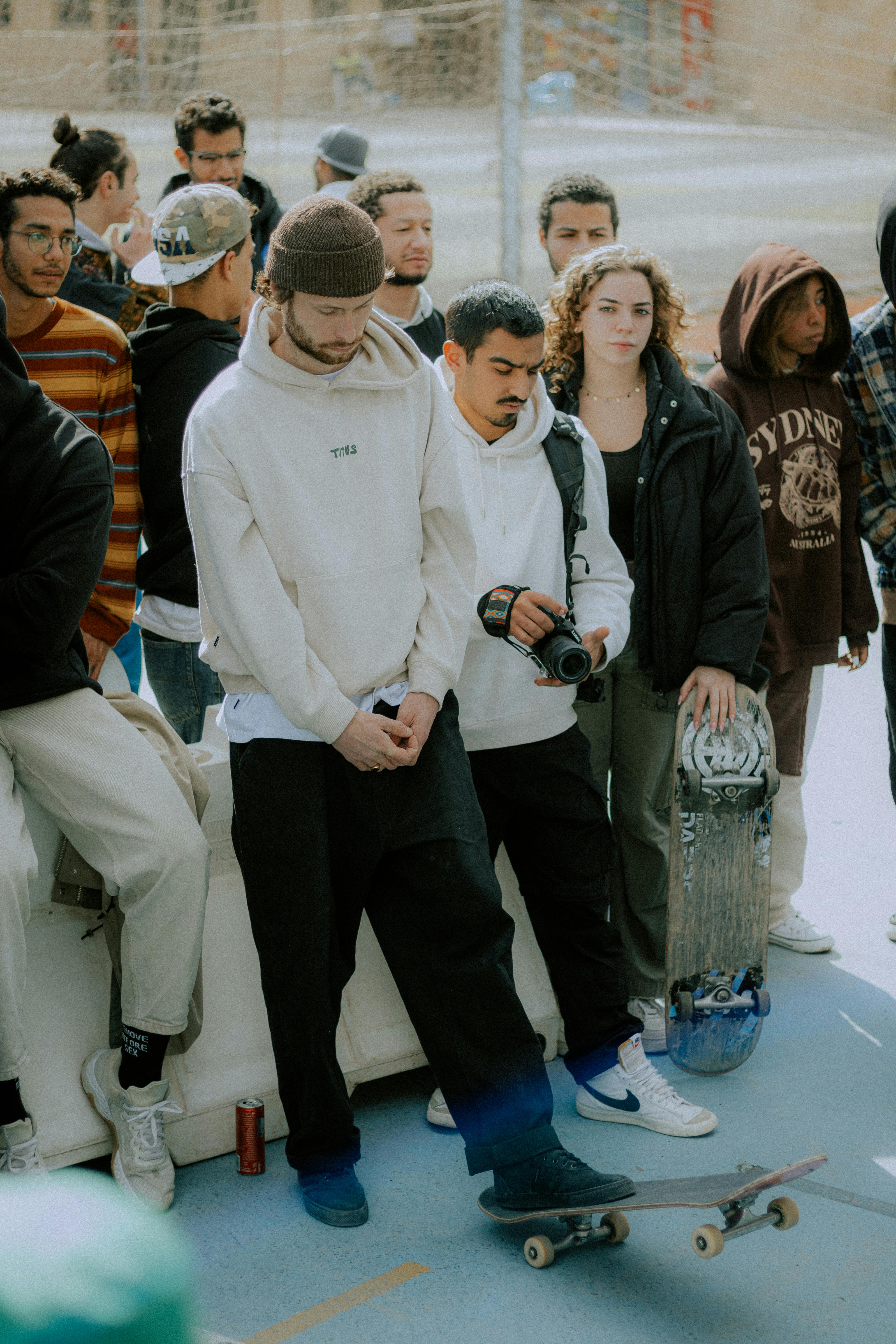 A group of people standing around a skateboard · Free Stock Photo