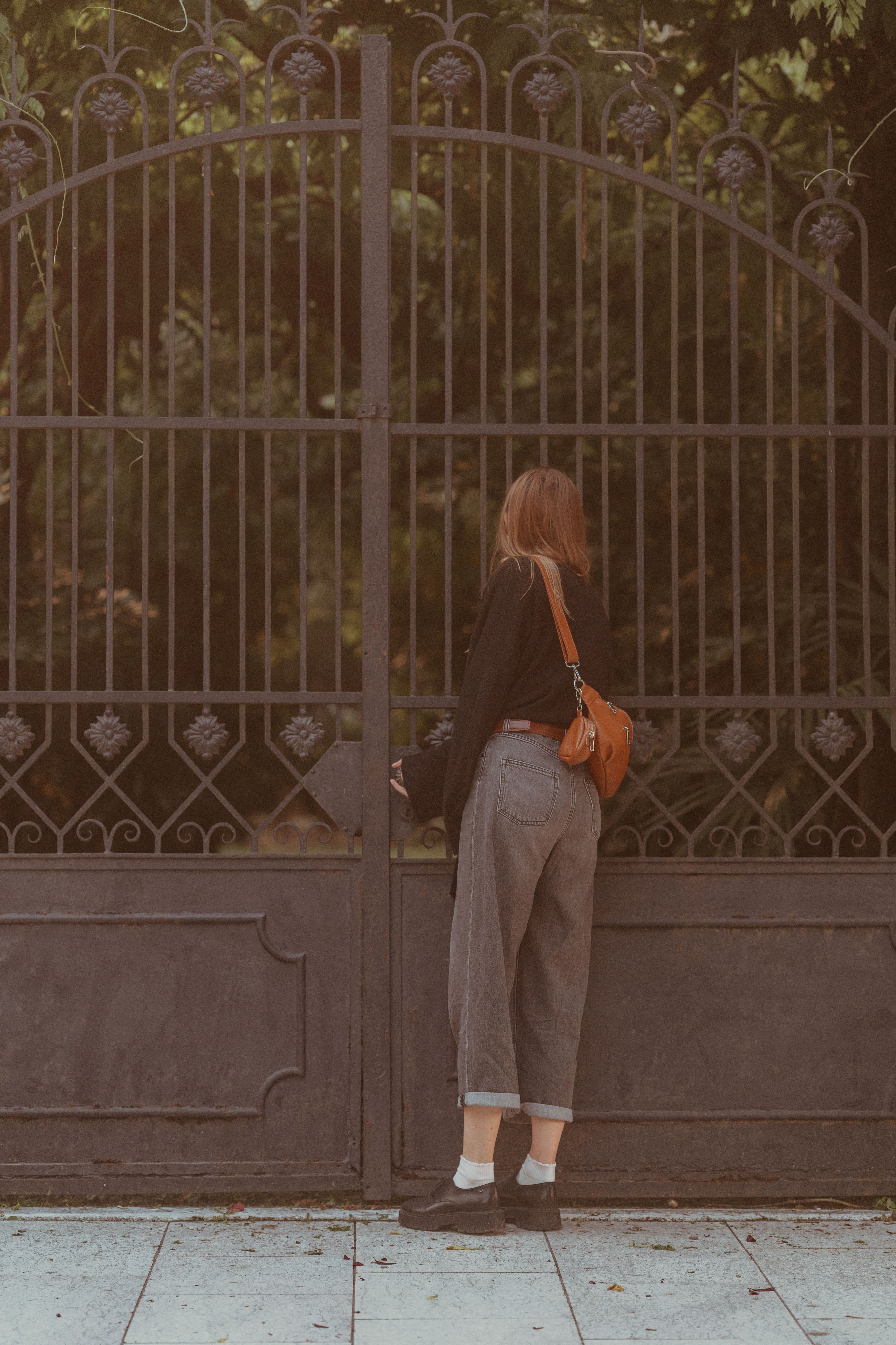 A woman standing in front of a gate · Free Stock Photo