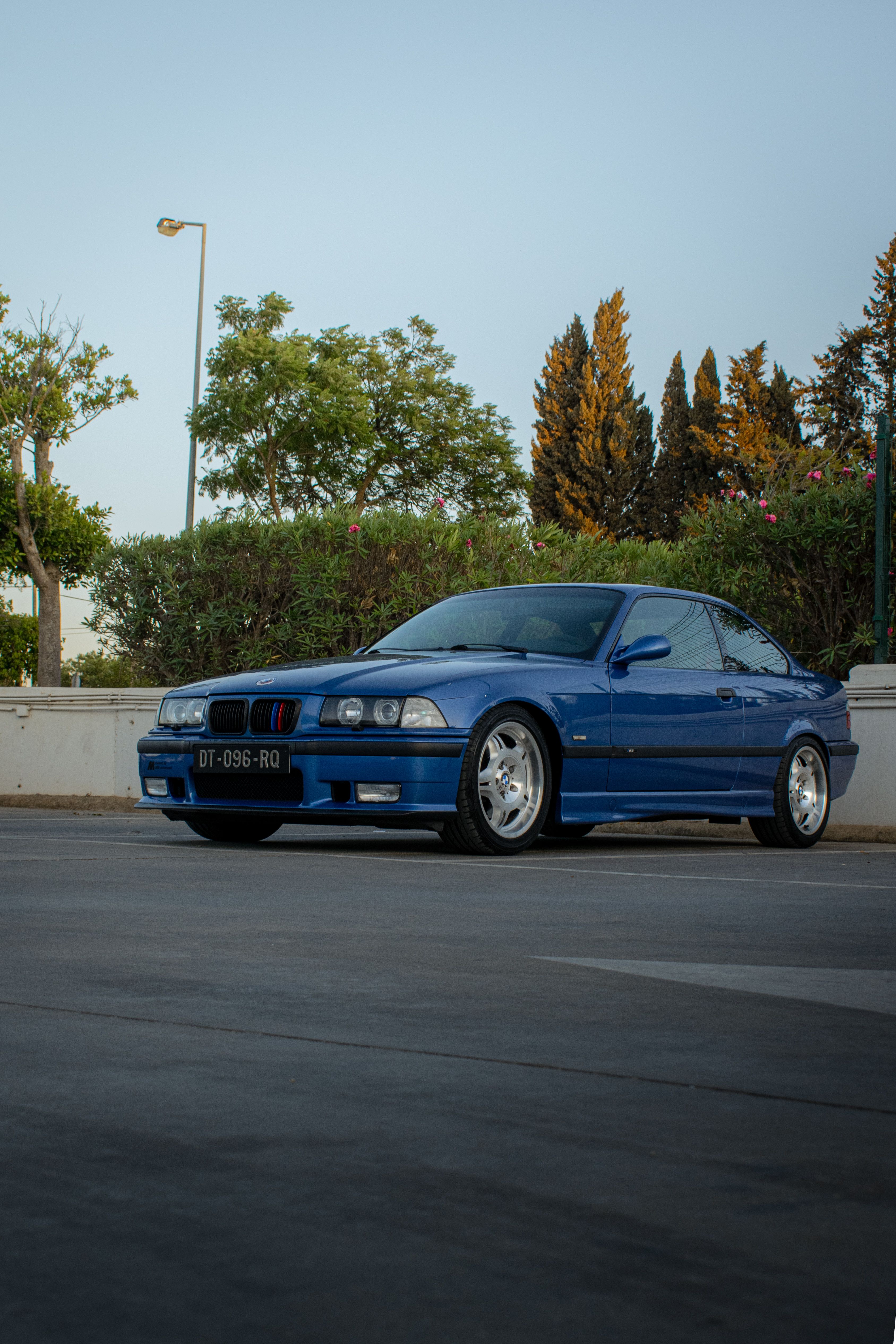 A blue bmw e36 coupe parked on the side of the road · Free Stock Photo