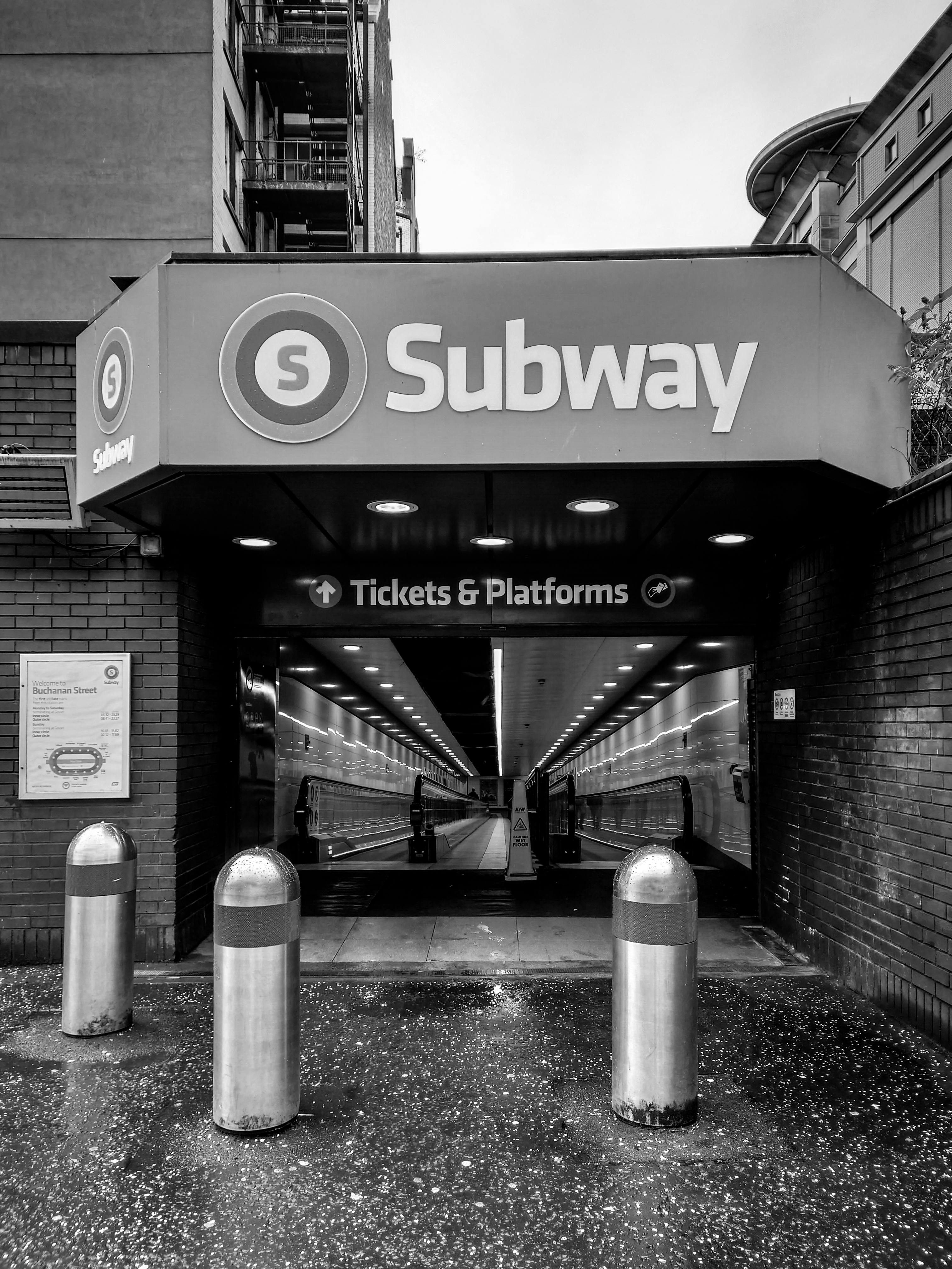 A subway station entrance with a sign that says subway · Free Stock Photo