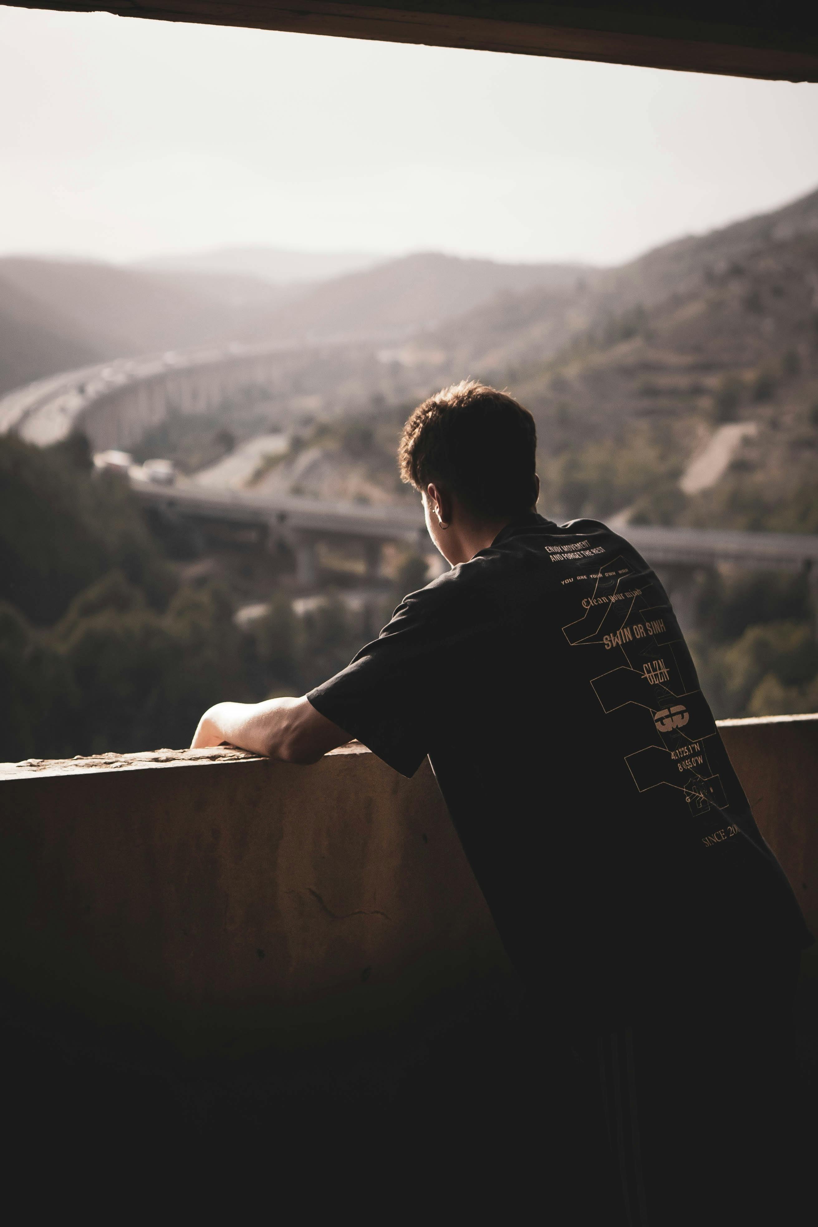 A man looking out over a valley · Free Stock Photo