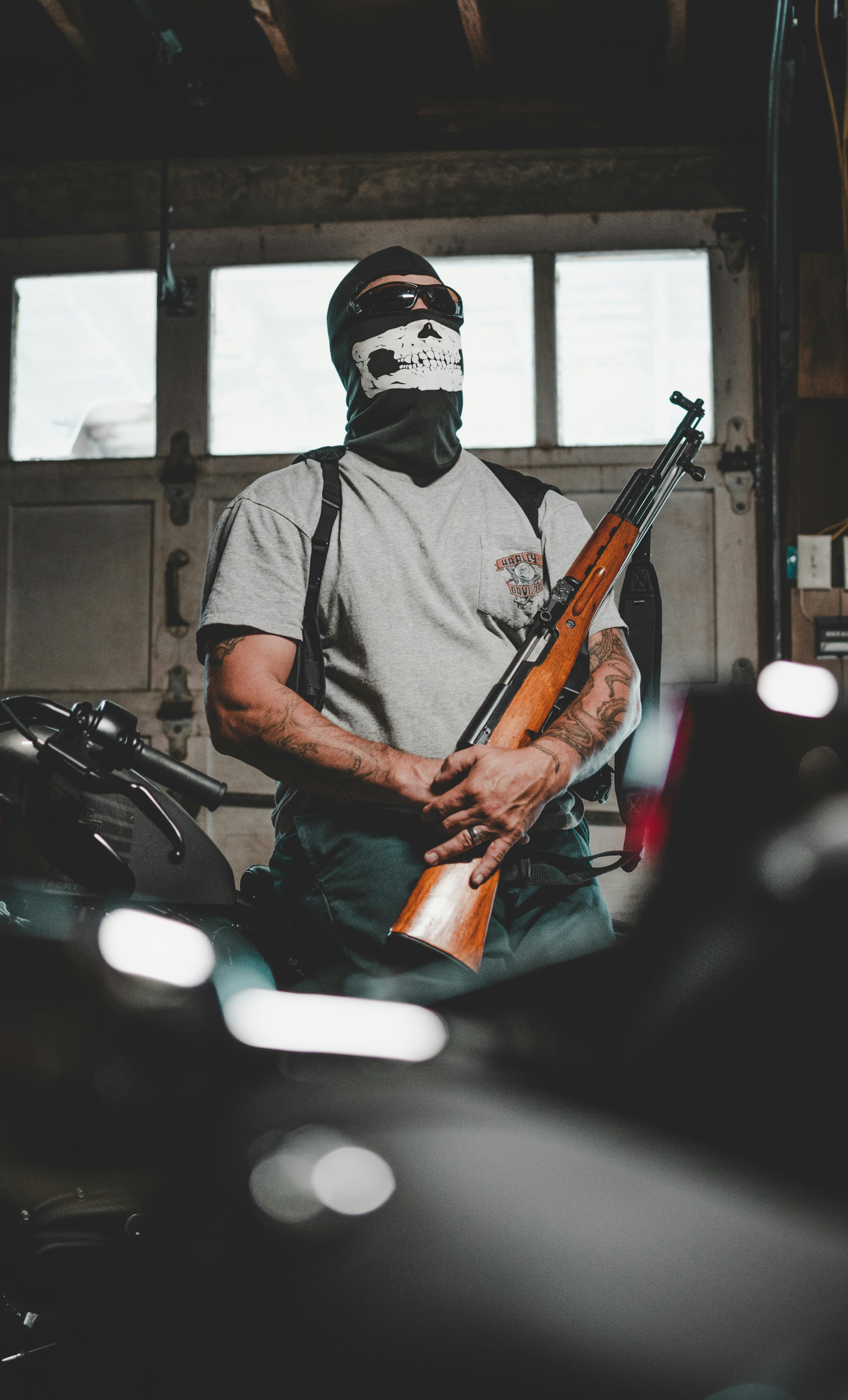 Man Wearing Mask Carrying Rifle · Free Stock Photo