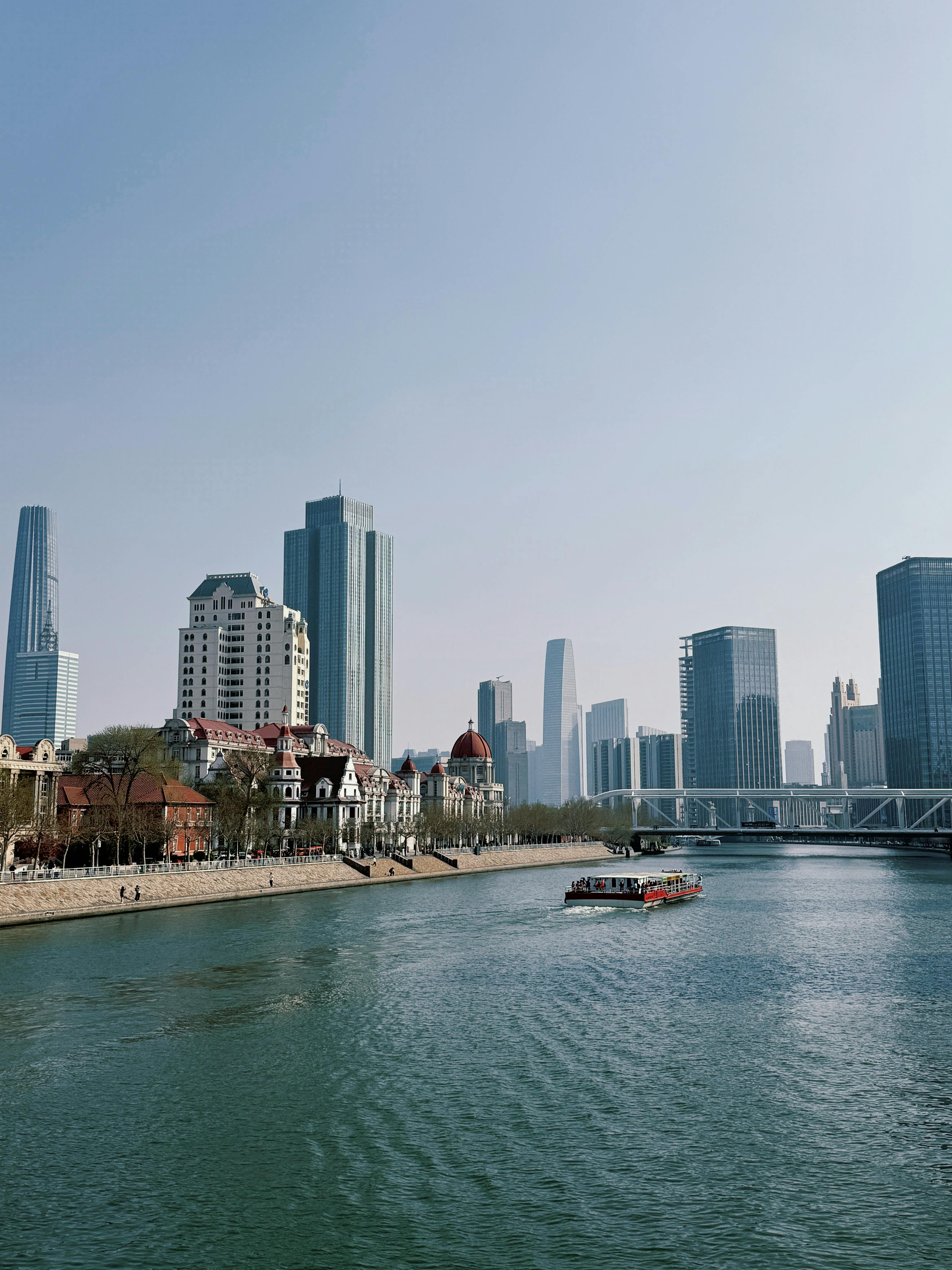 A river with a boat in it near some tall buildings · Free Stock Photo