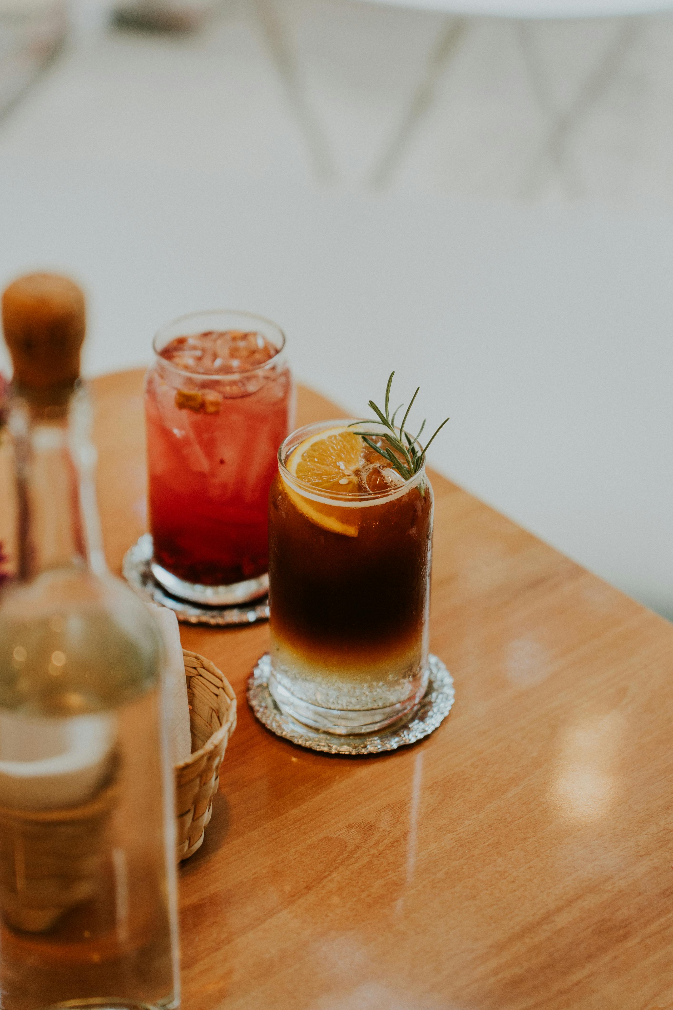 A table with two drinks and a bottle of wine · Free Stock Photo