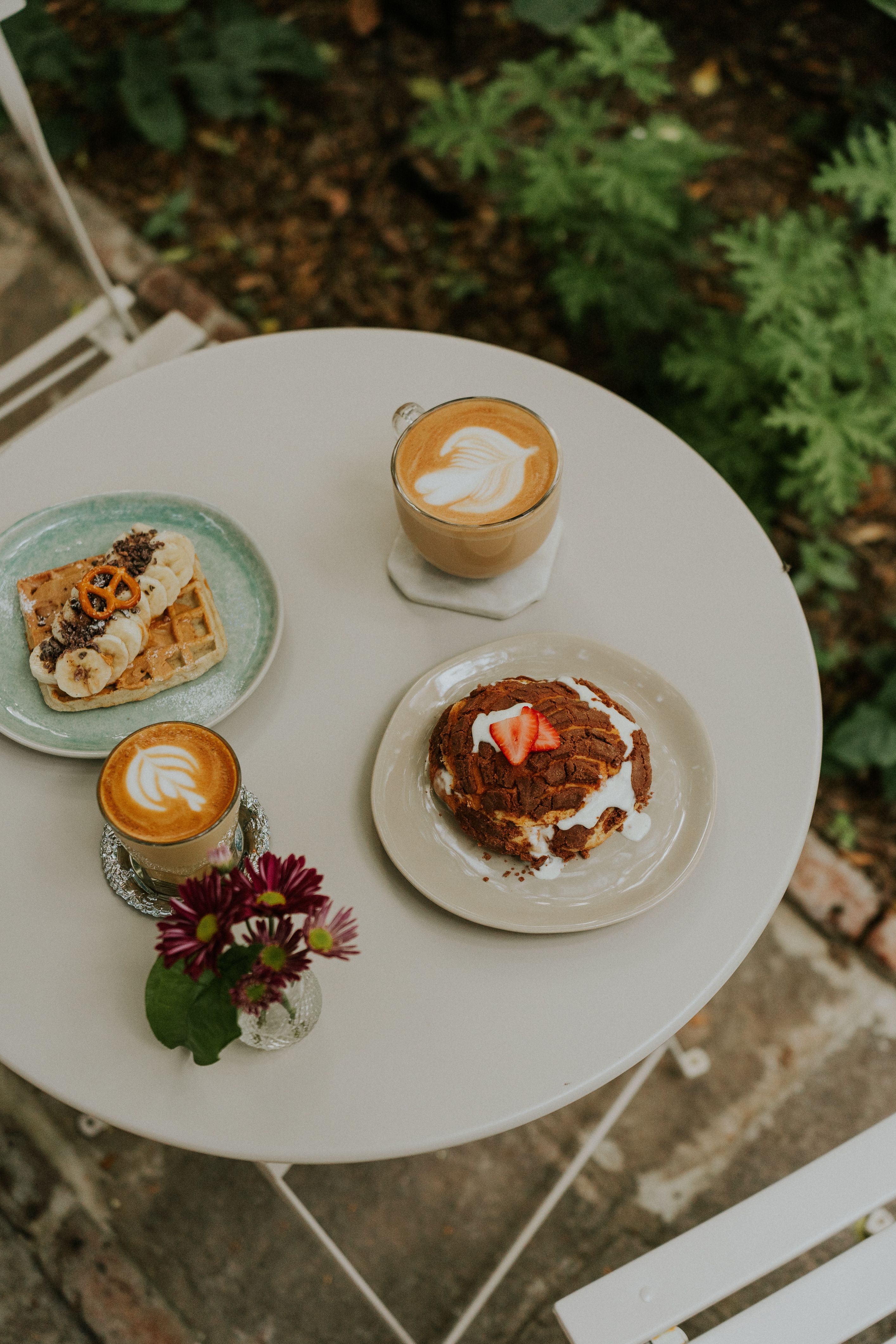 A table with two plates of food and coffee · Free Stock Photo