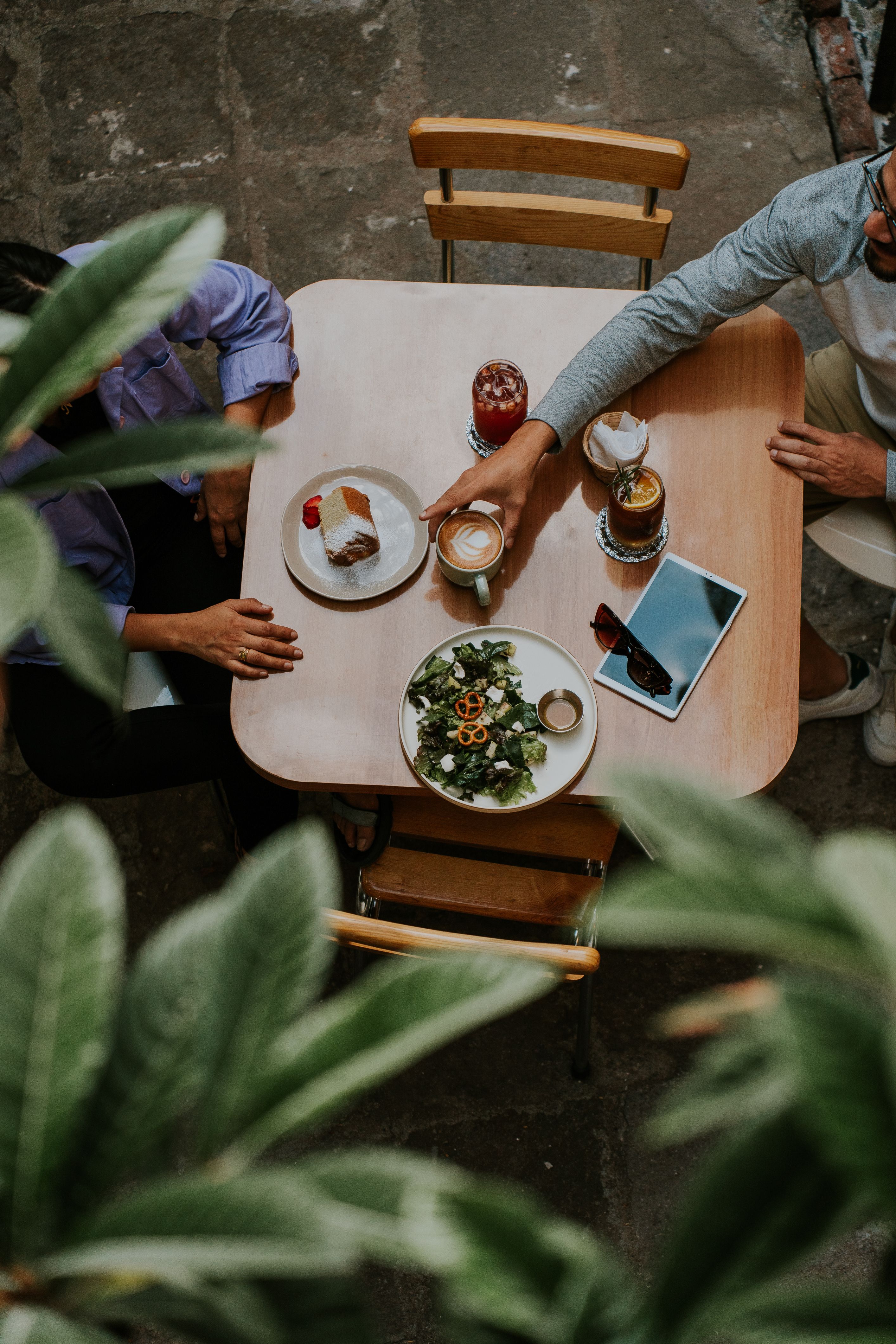 Two people sitting at a table with food and drinks · Free Stock Photo