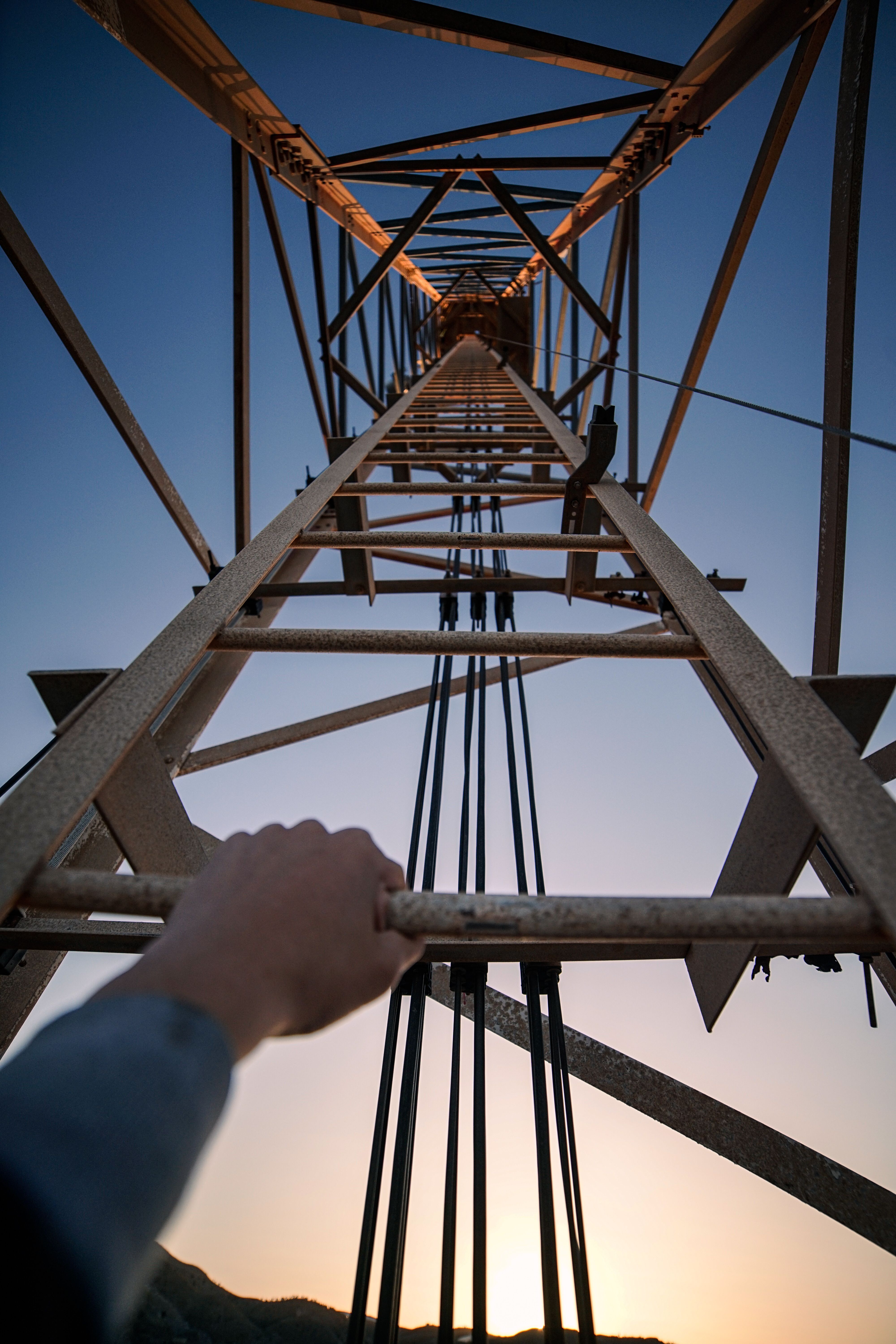 A person's hand reaching up to the top of a tower · Free Stock Photo
