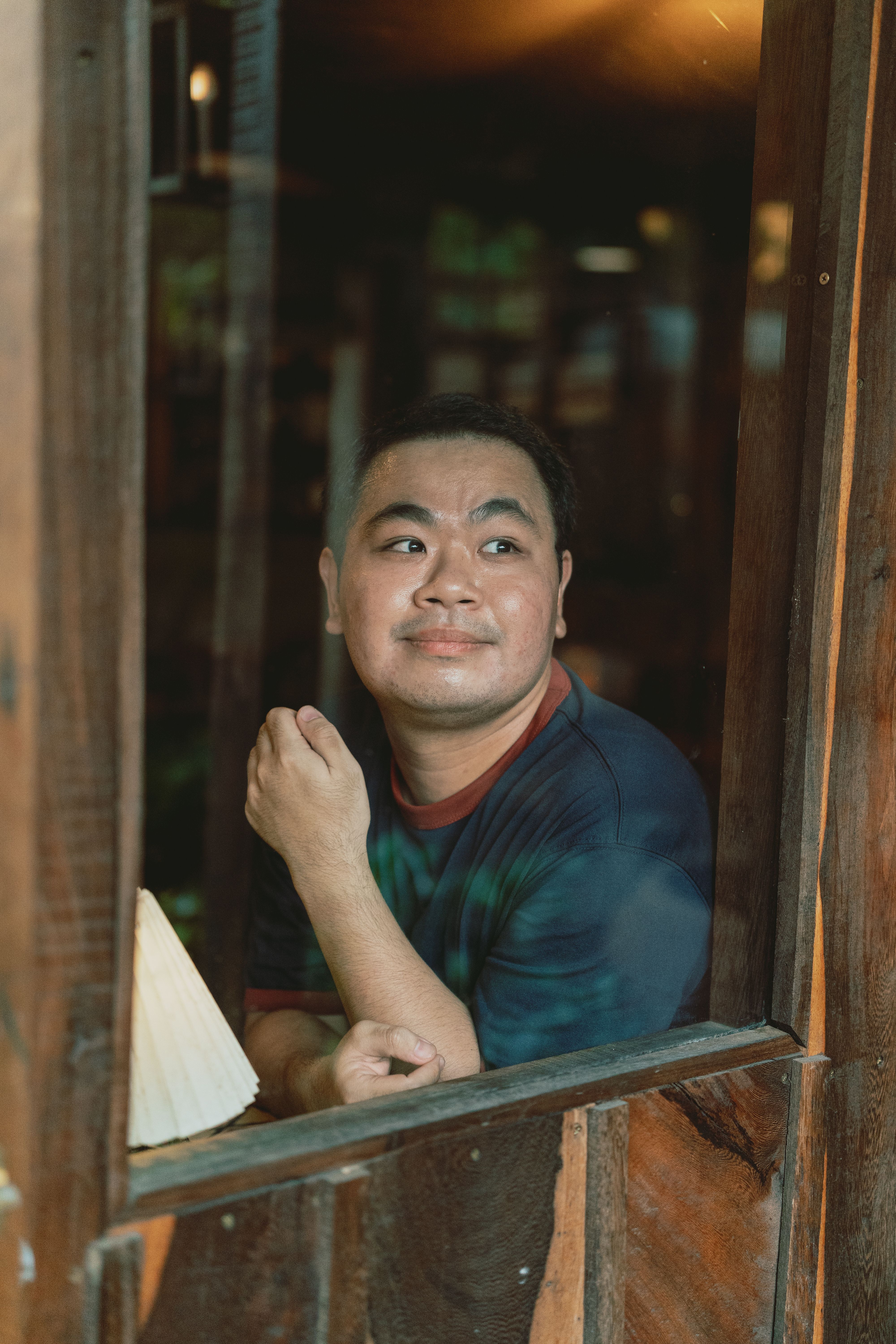 A man leaning out of a window with a smile on his face · Free Stock Photo