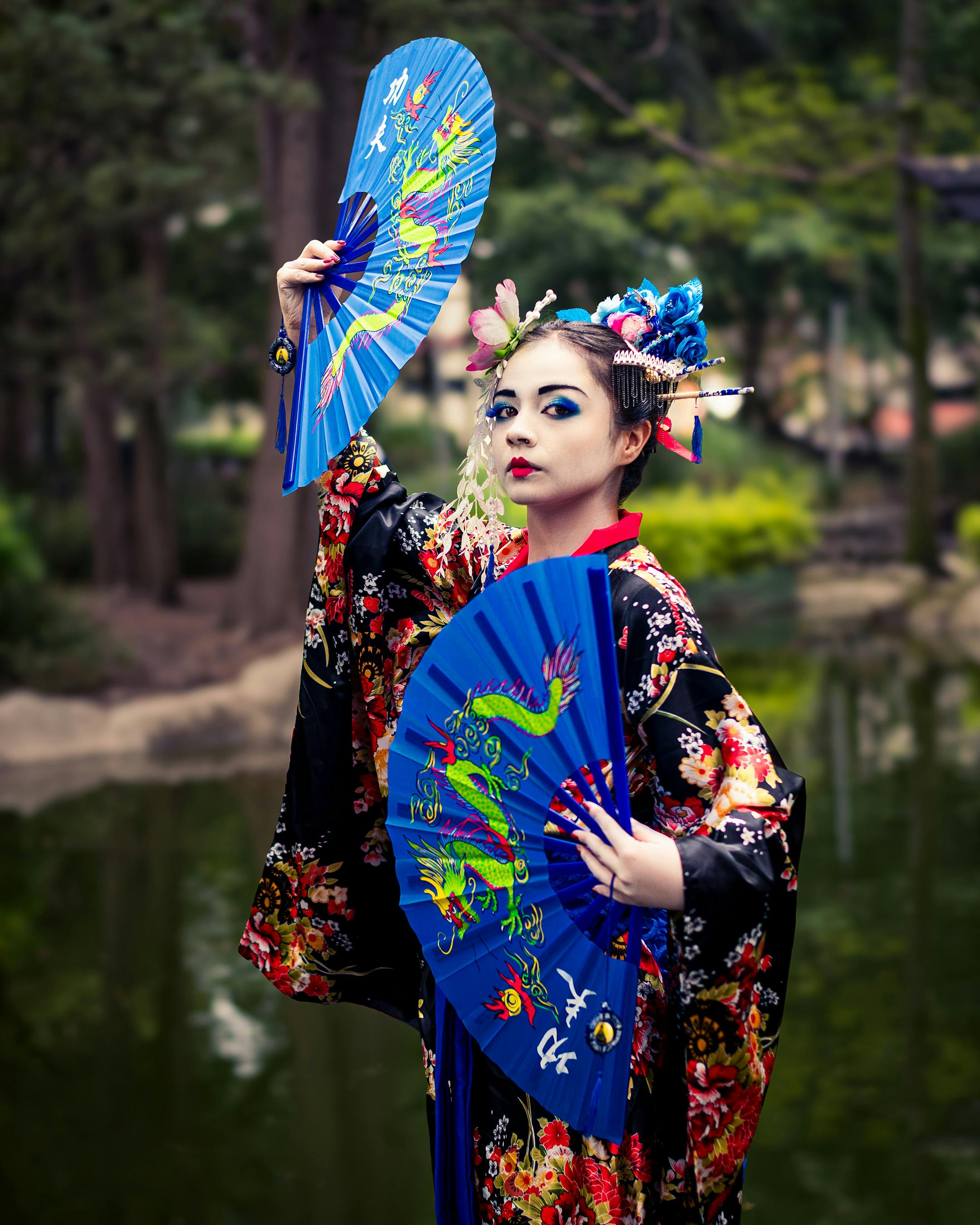 A woman in a blue and black costume holding two blue fans · Free Stock ...