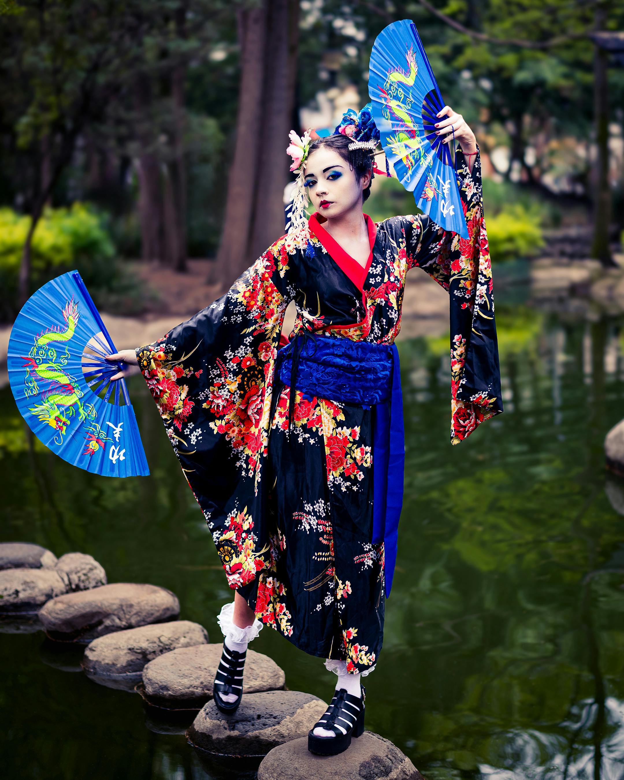 A woman in a geisha costume holding a fan · Free Stock Photo