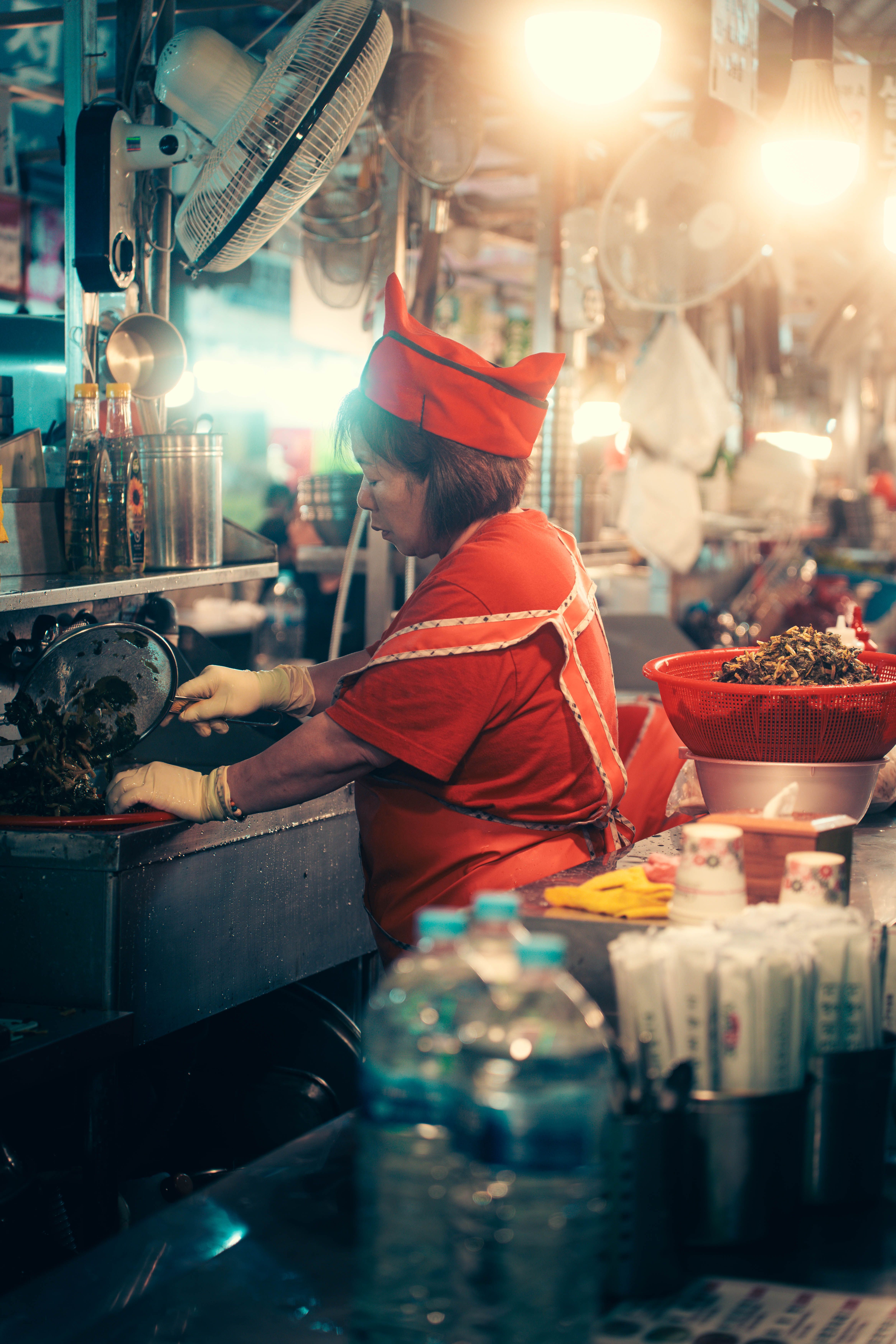 A woman in red is cooking in a kitchen · Free Stock Photo