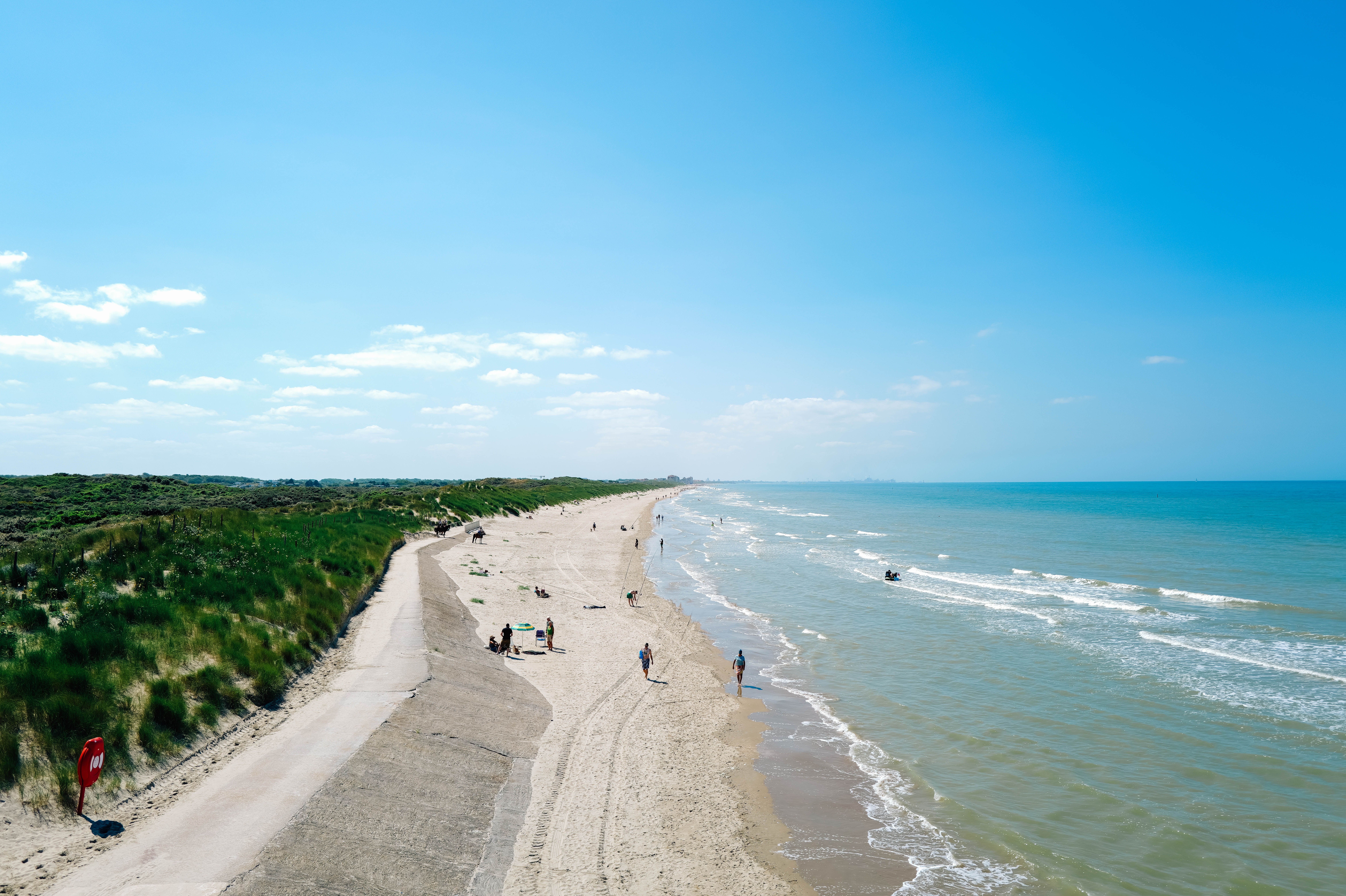 A beach with a sandy beach and a blue sky · Free Stock Photo