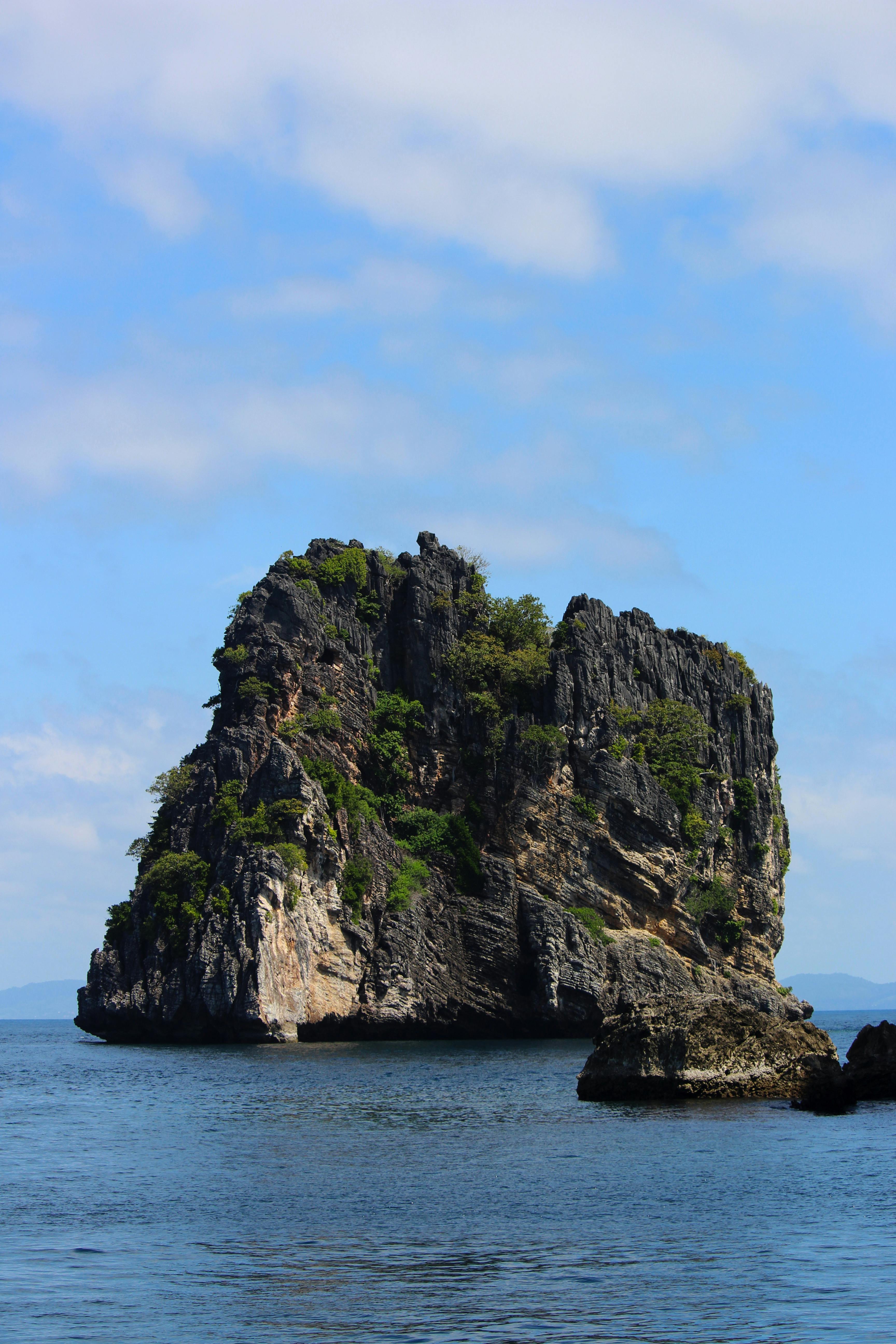 A small rock formation in the middle of the ocean · Free Stock Photo