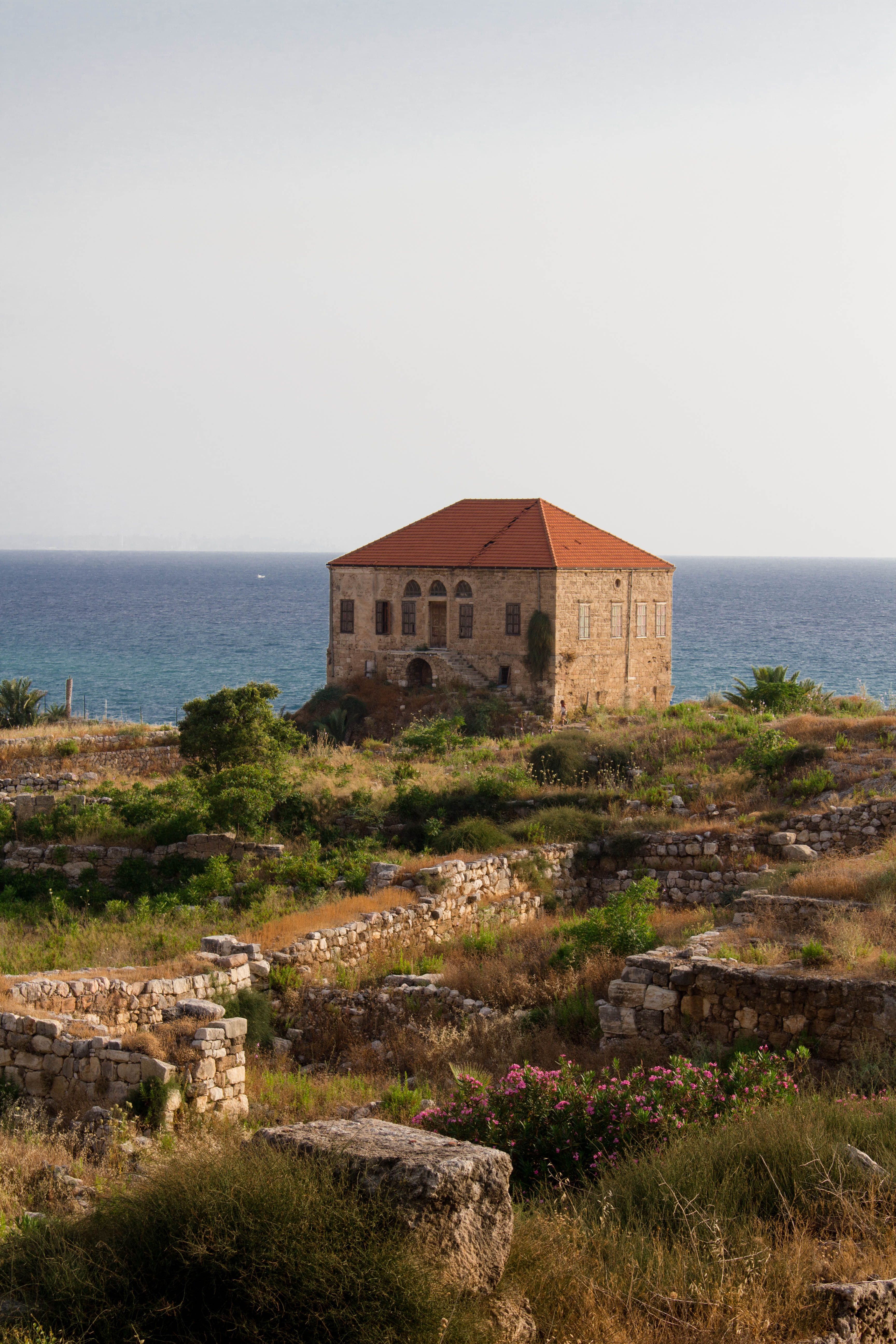 An old stone building sits on top of a hill overlooking the ocean ...