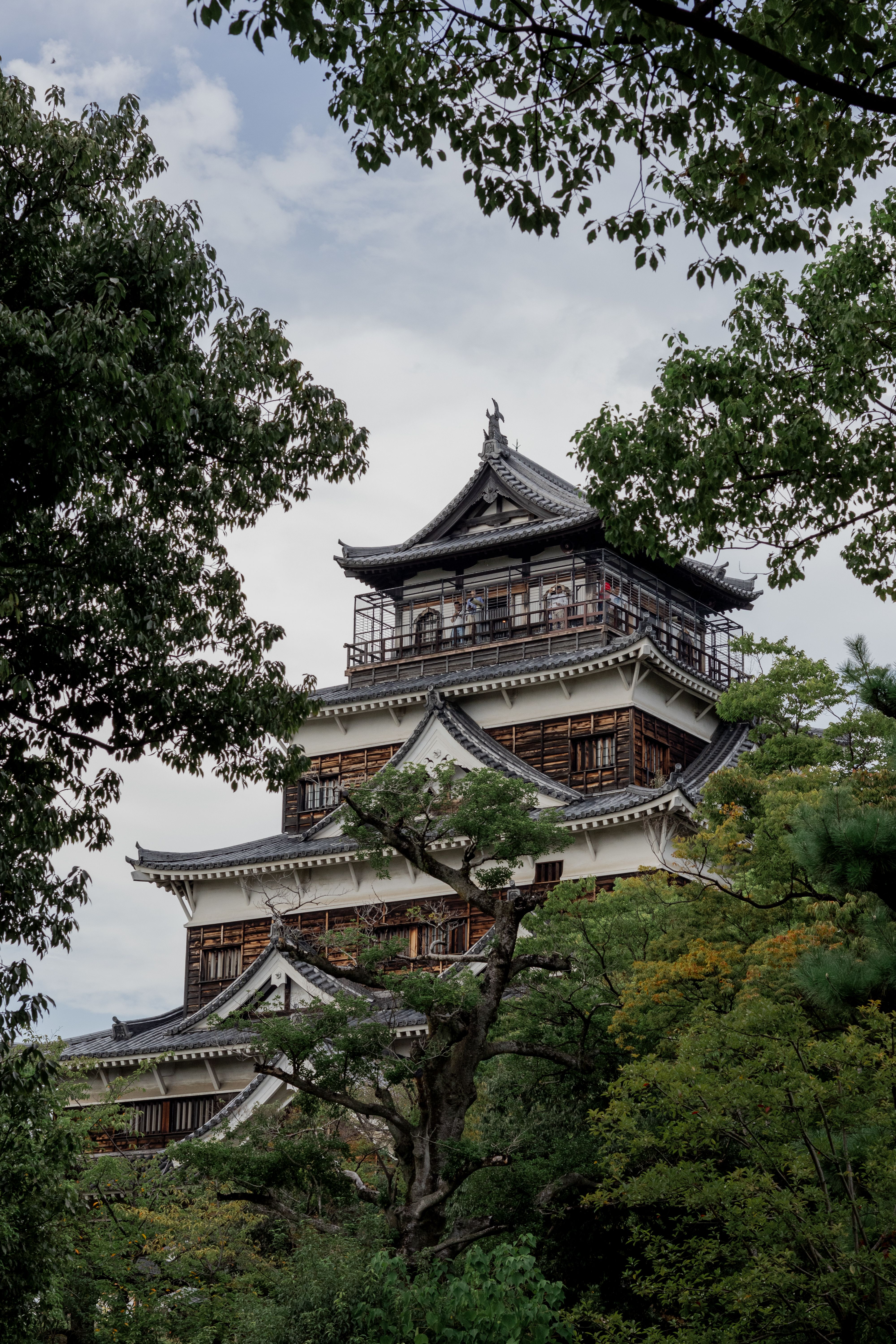 A japanese castle is surrounded by trees · Free Stock Photo