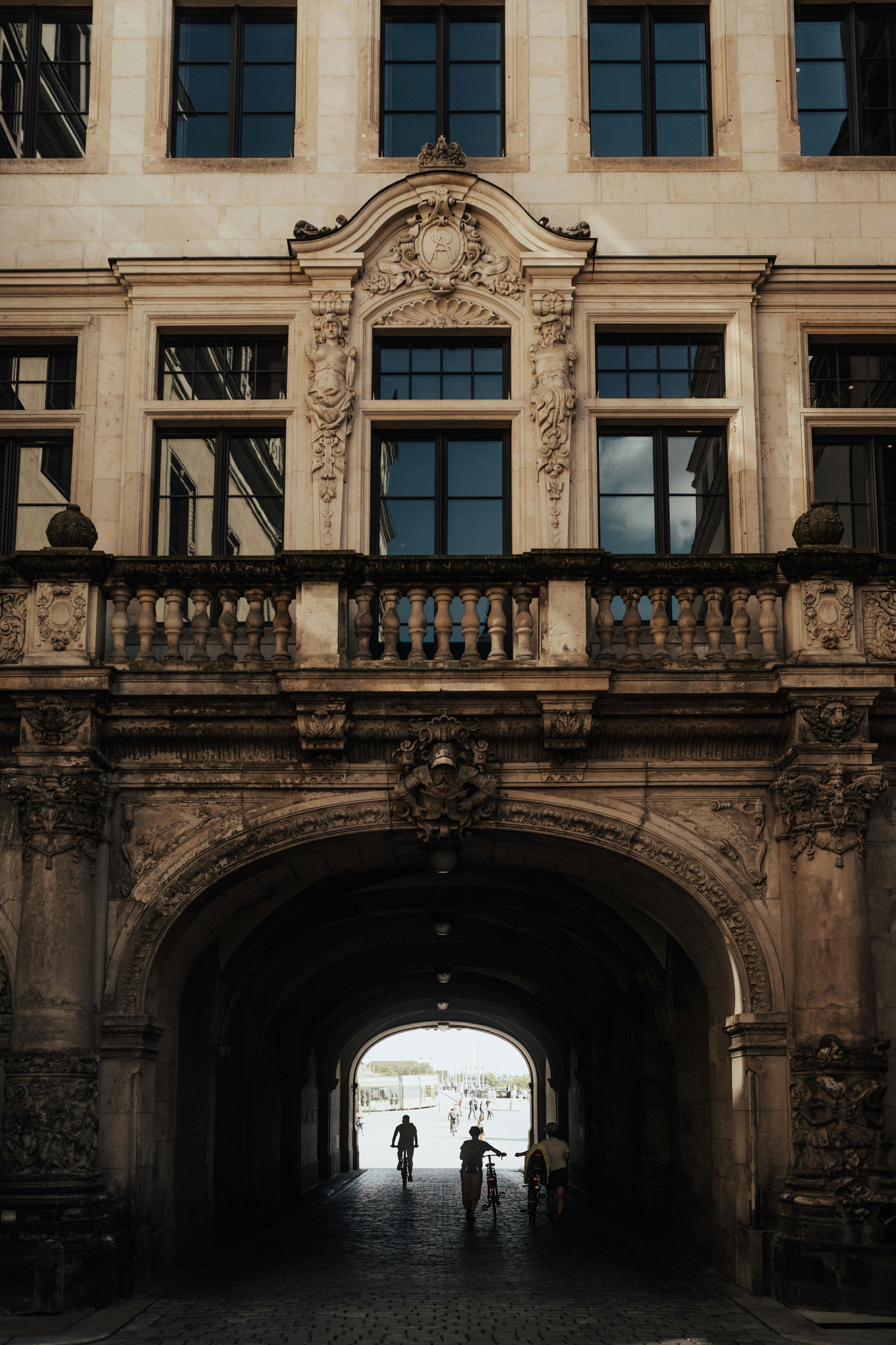 A man and woman walk through an archway · Free Stock Photo