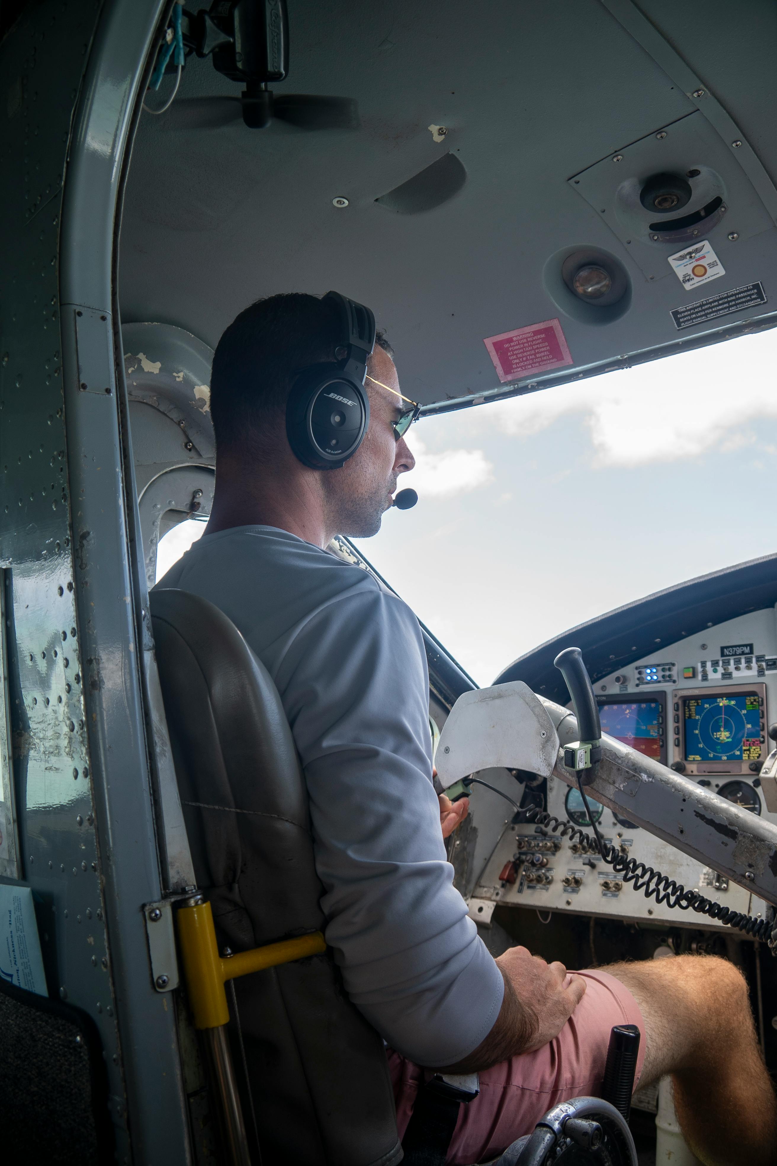 A man sitting in the cockpit of a small plane · Free Stock Photo