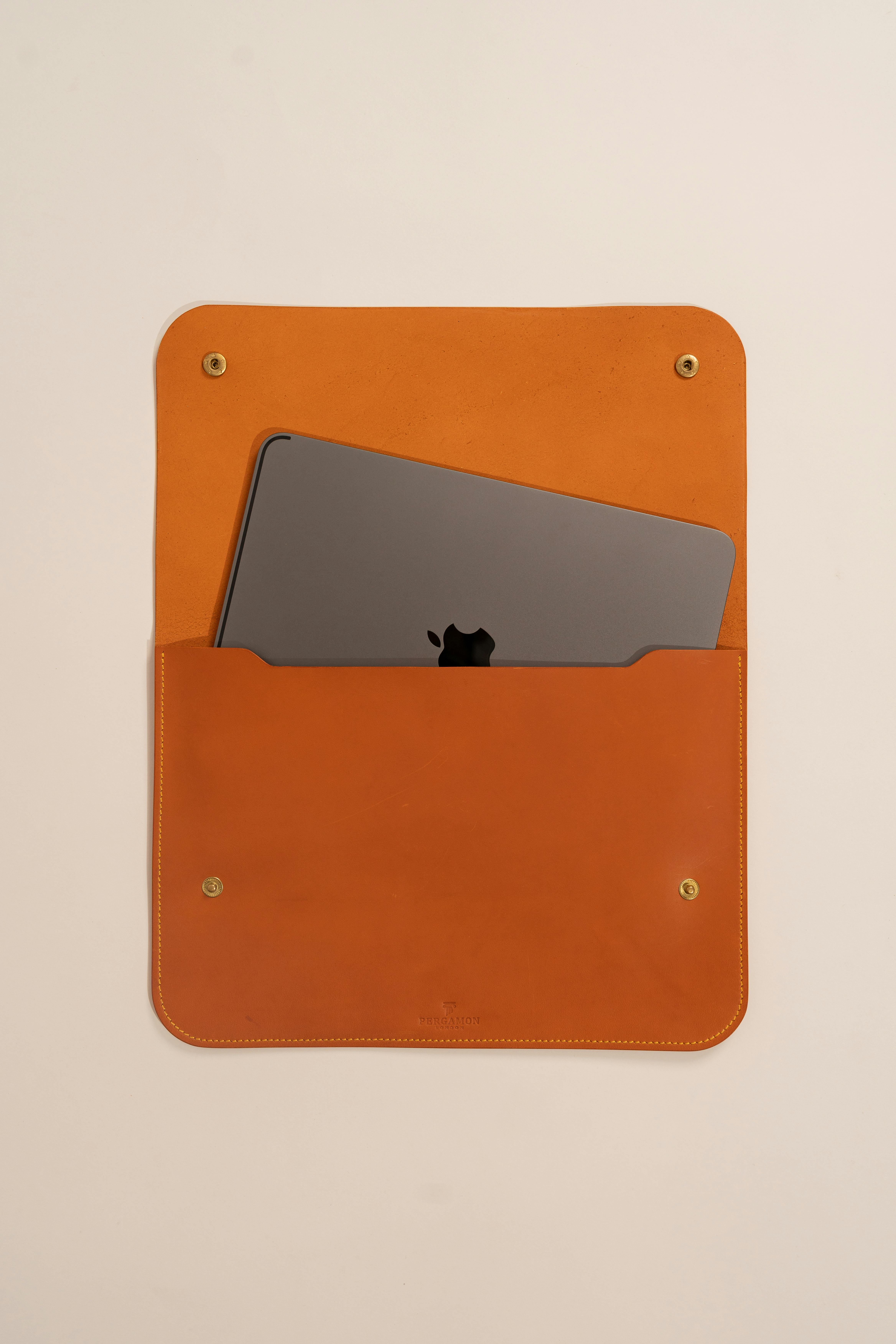 An apple laptop case with a leather strap · Free Stock Photo