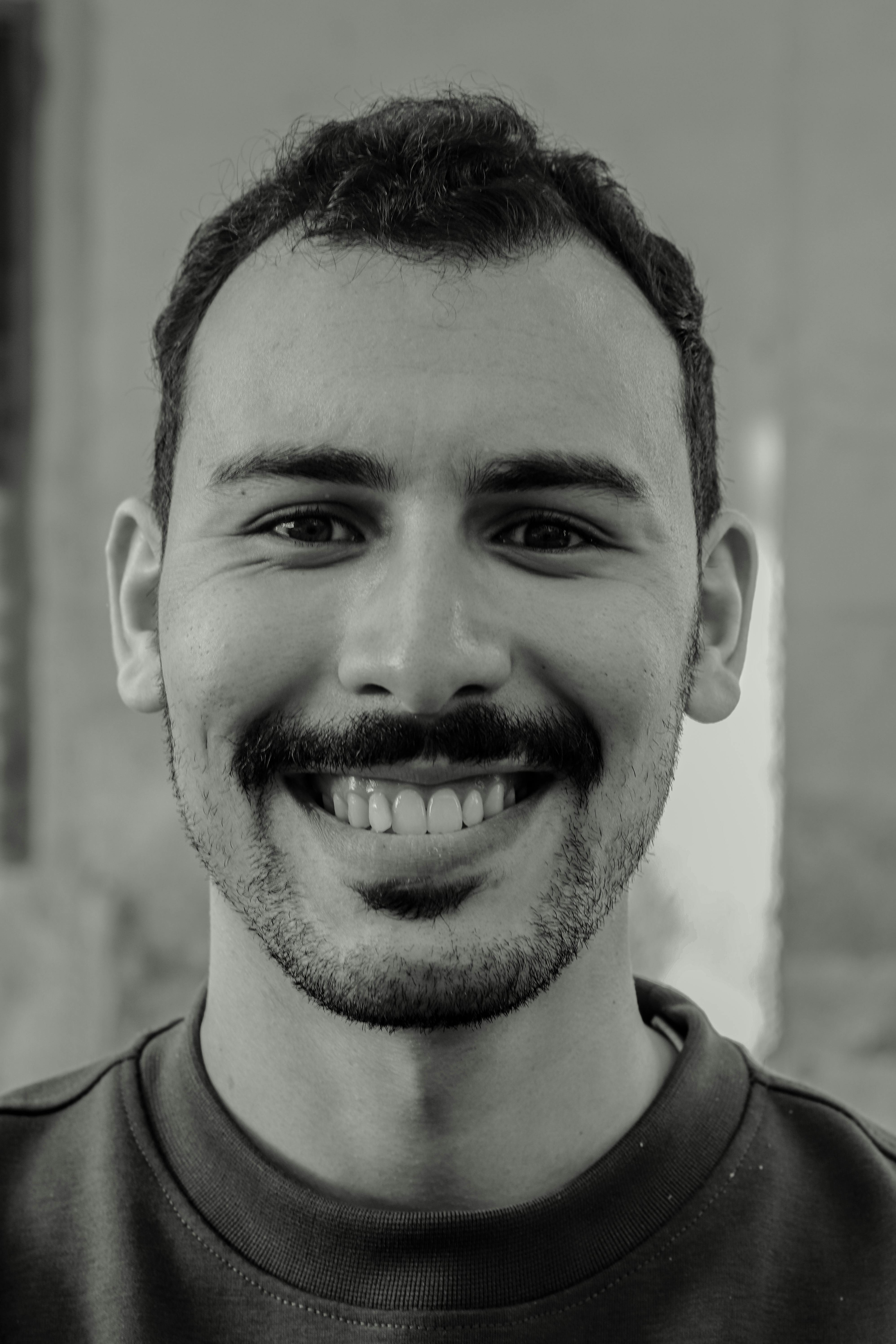 A man with a mustache smiles for the camera · Free Stock Photo