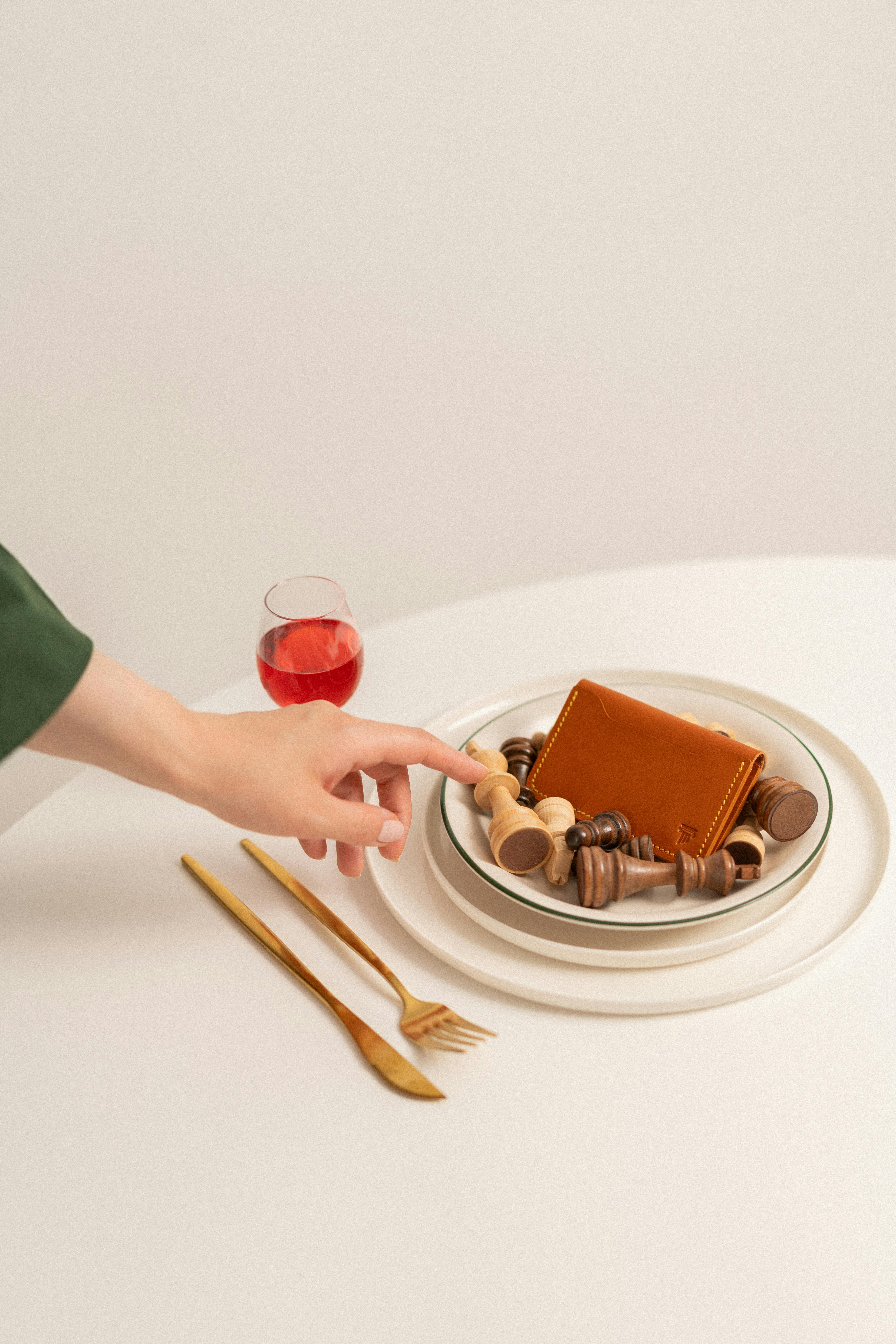 Woman Hand over Plate with Wallets and Chess Pawns · Free Stock Photo