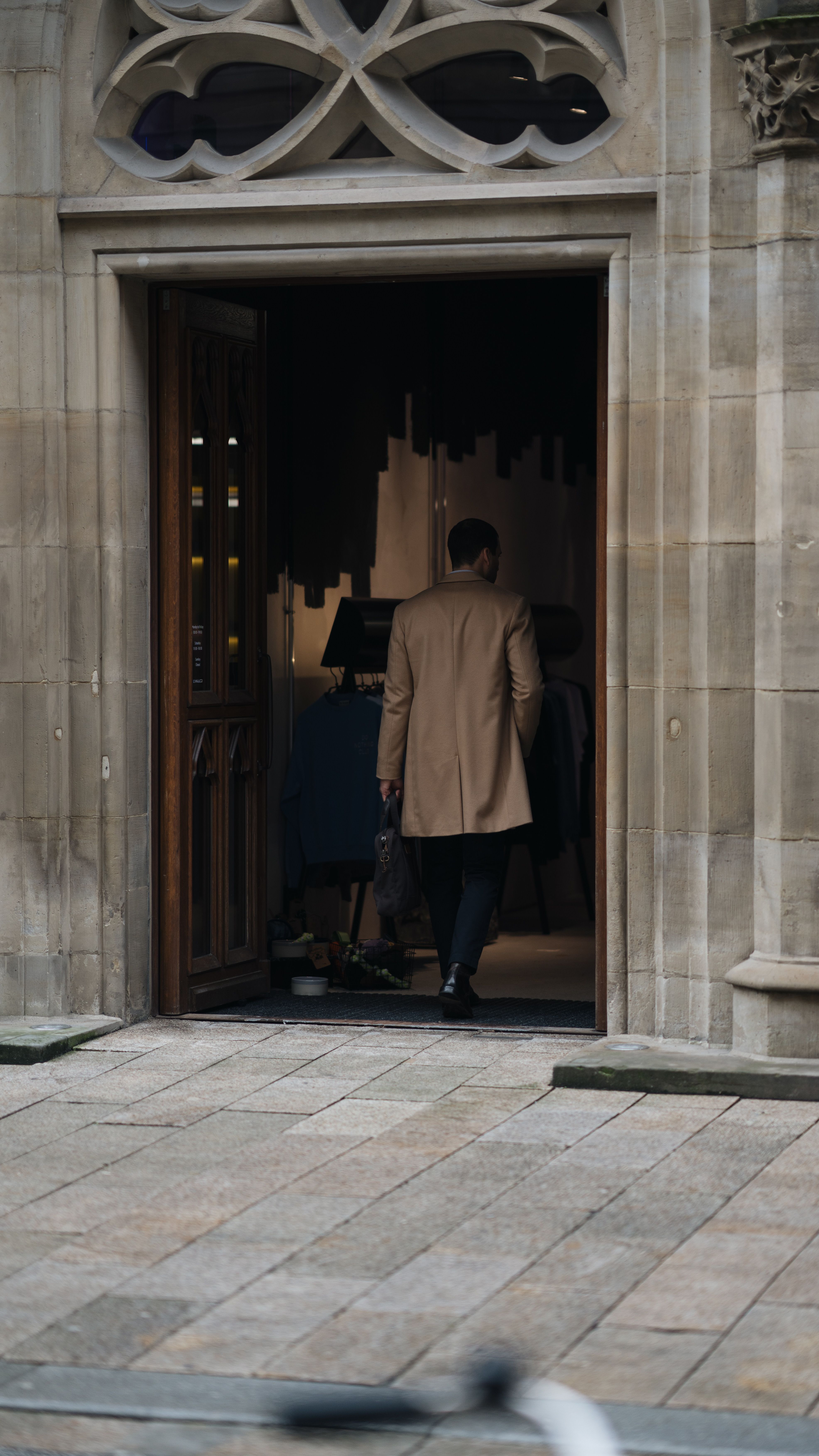 A man in a coat walking out of a church · Free Stock Photo