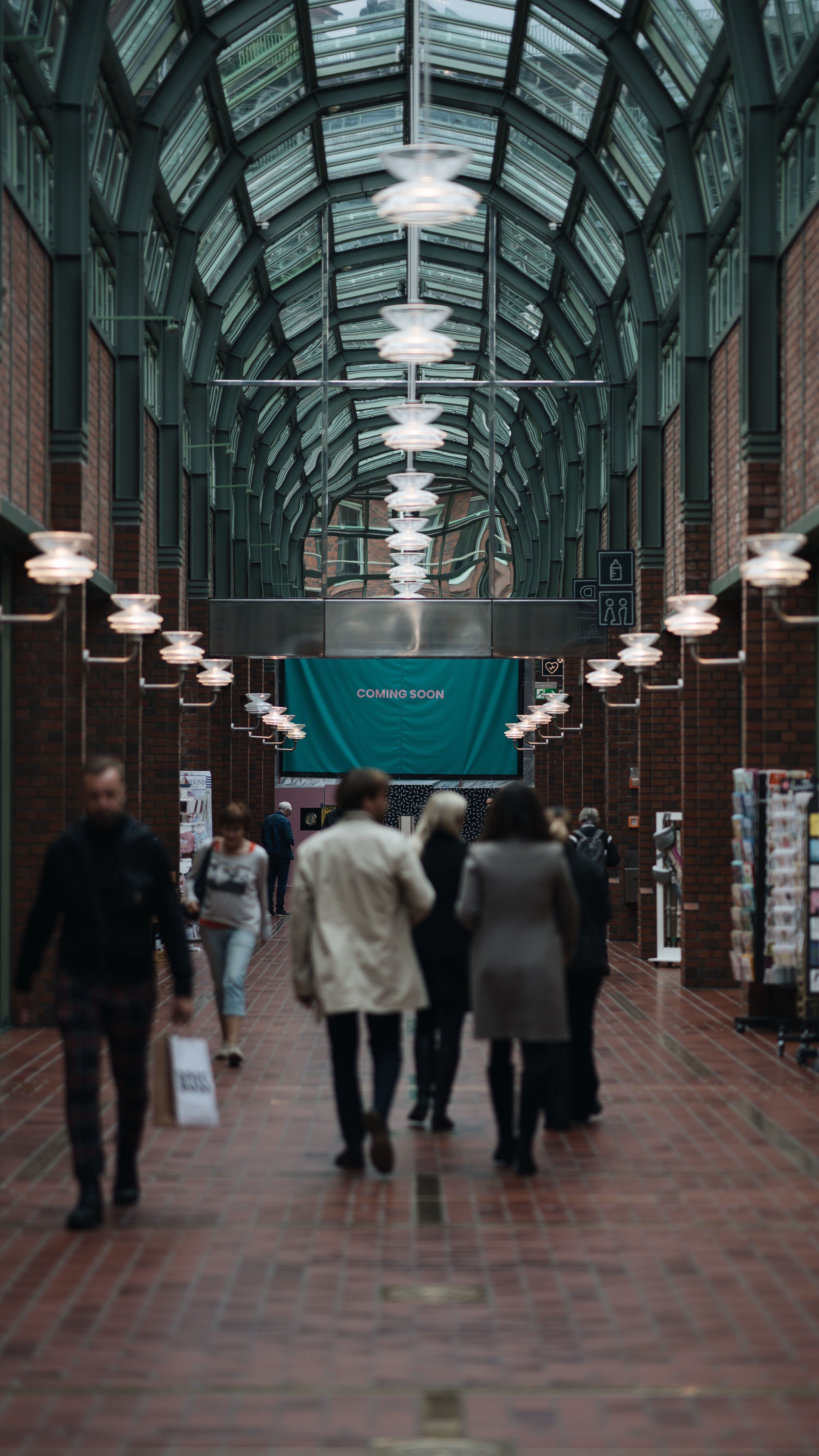 People walking through a large brick building · Free Stock Photo