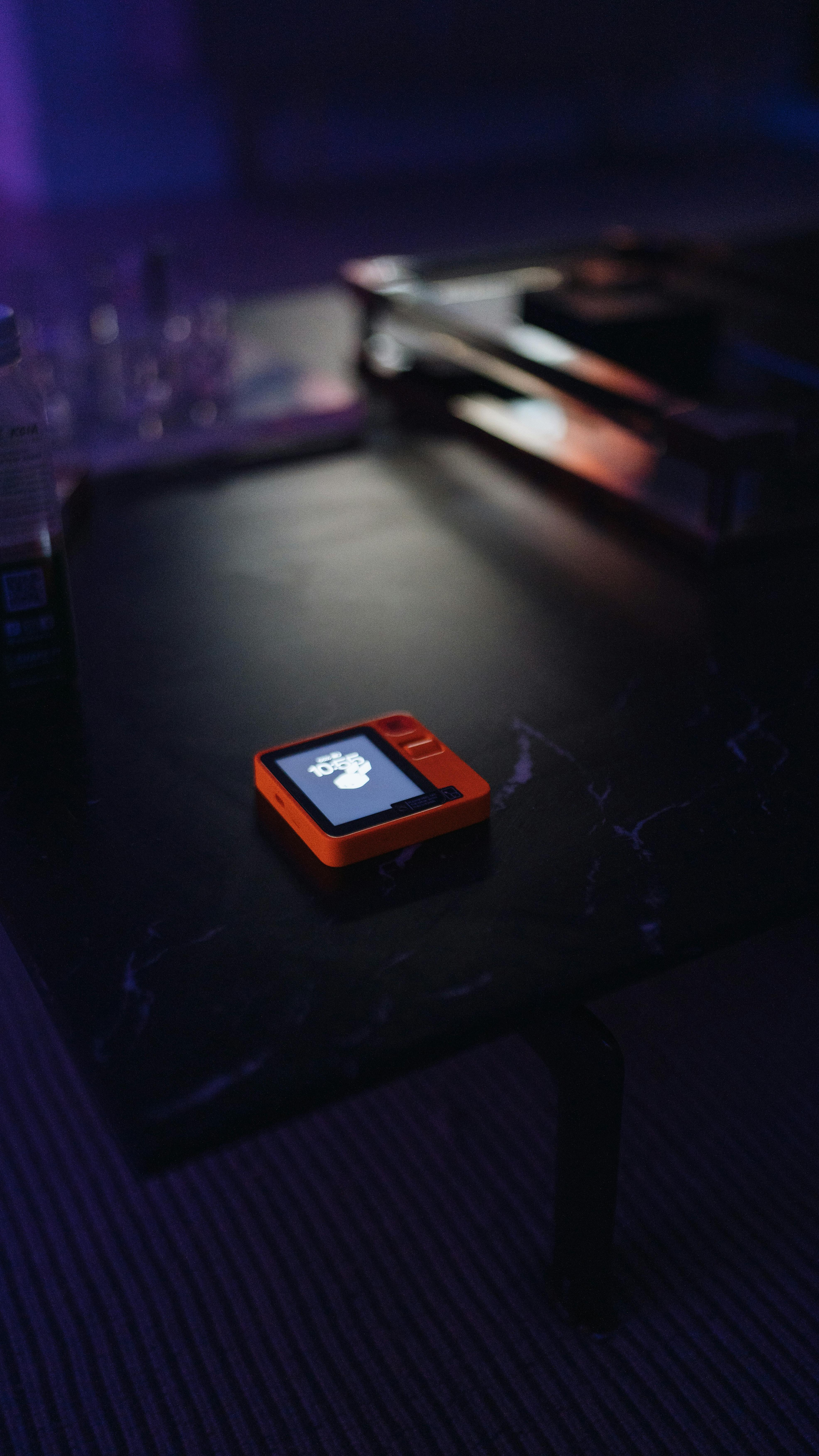 A small orange device sitting on top of a table · Free Stock Photo