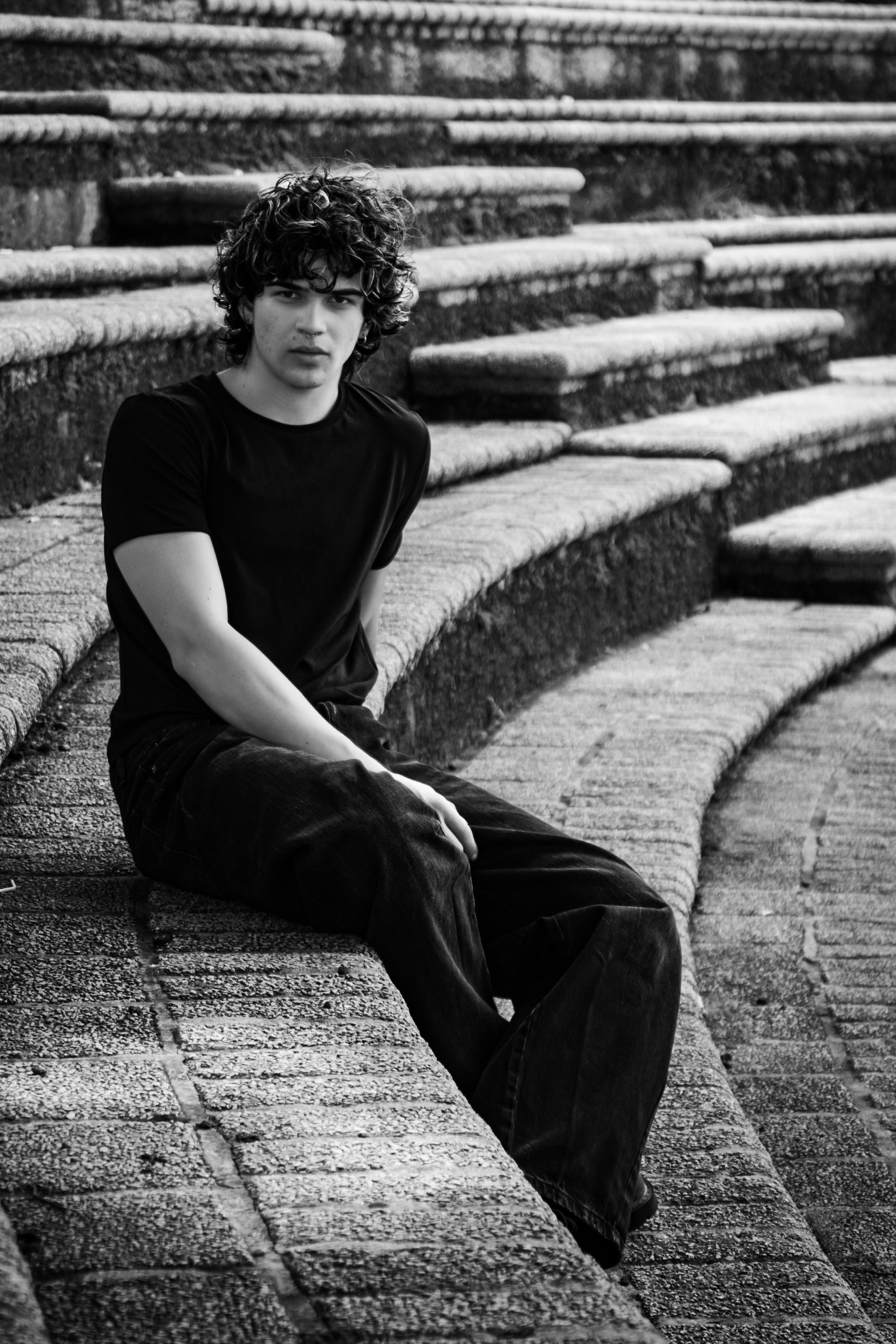 A young man sitting on the steps of a building · Free Stock Photo