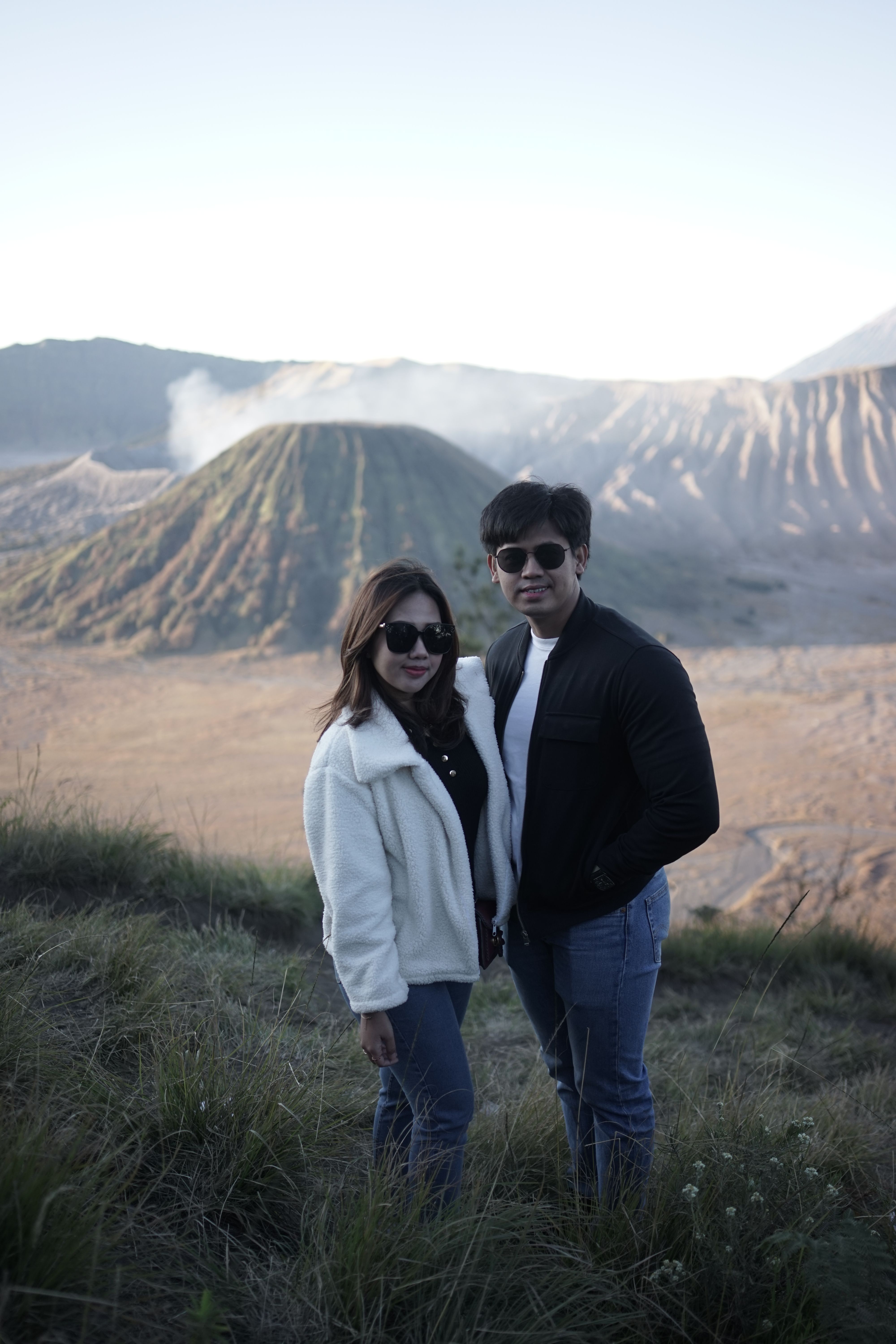 A couple posing for a photo in front of a volcano · Free Stock Photo