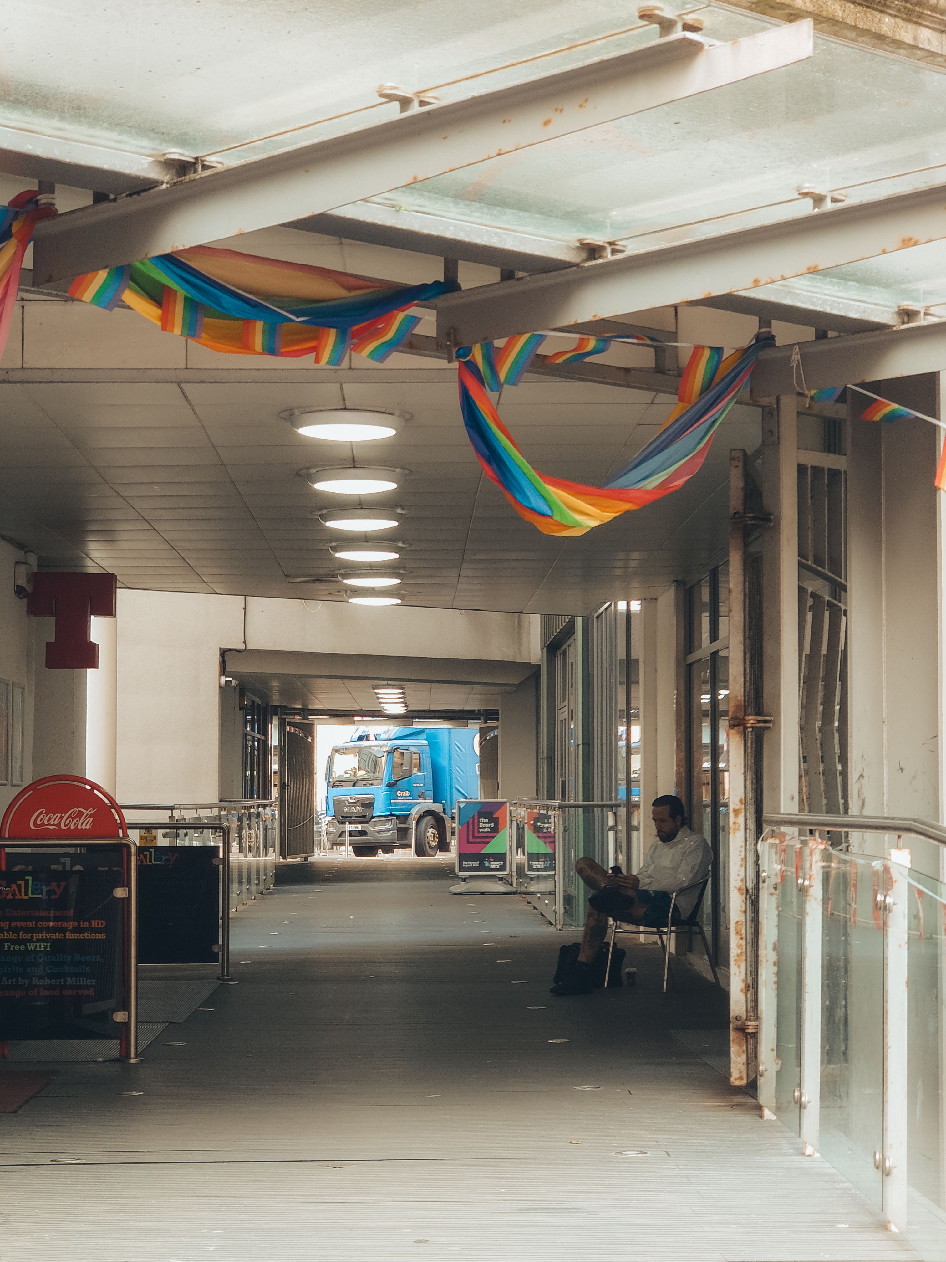 A long walkway with colorful banners hanging from the ceiling · Free ...
