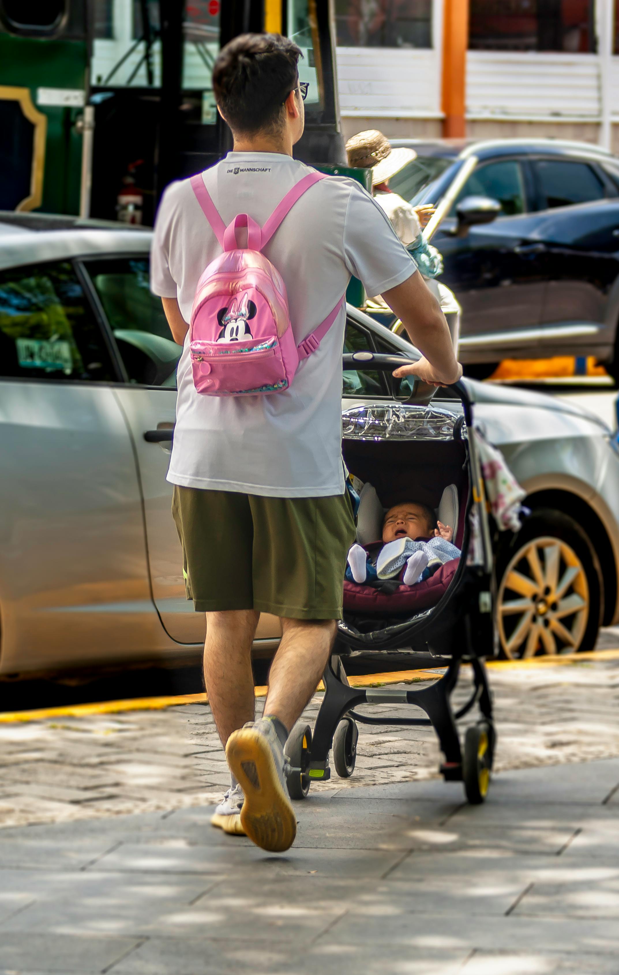 A man pushing a stroller with a baby in it · Free Stock Photo
