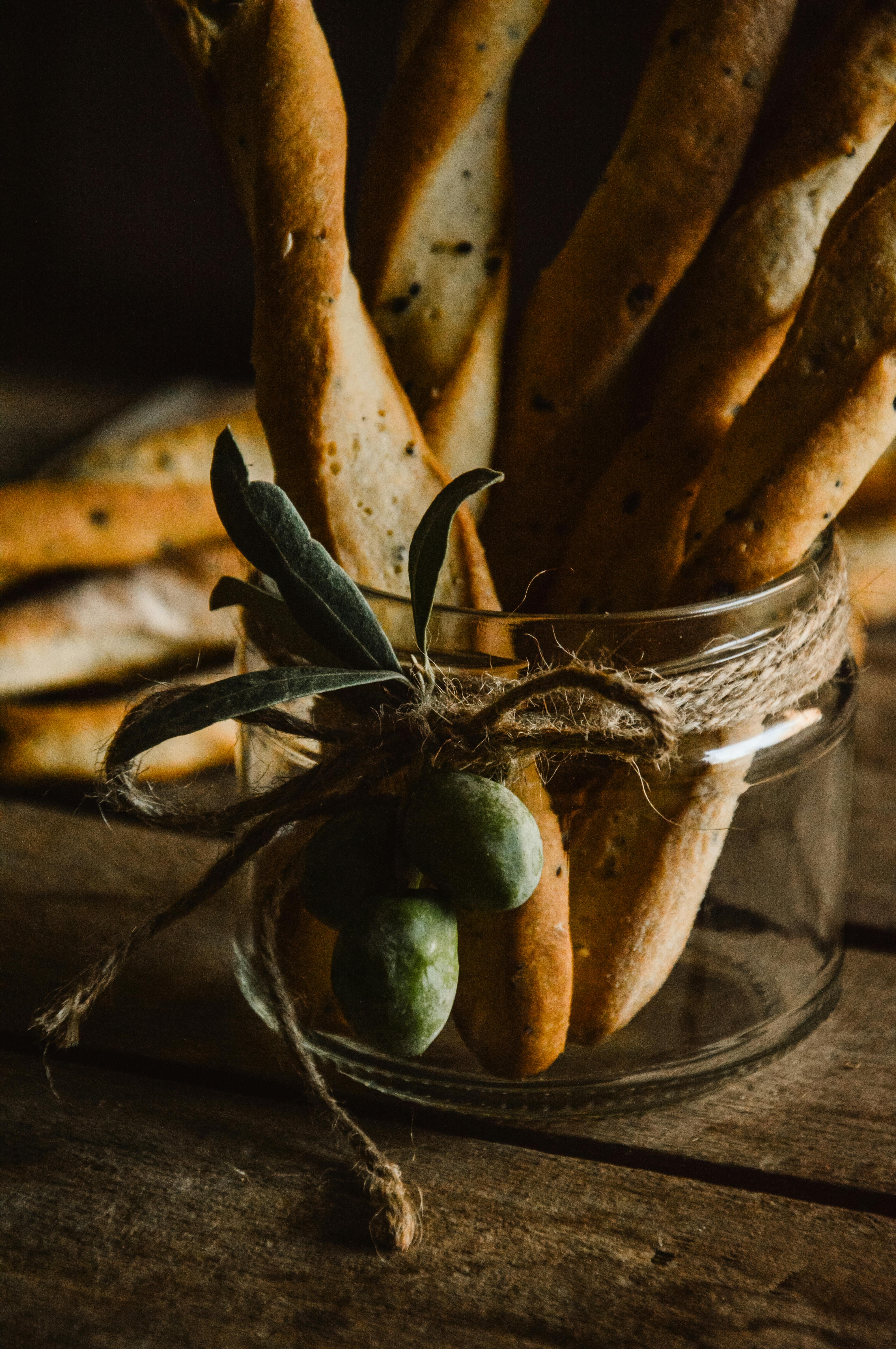 Breadsticks in a jar with olive leaves · Free Stock Photo