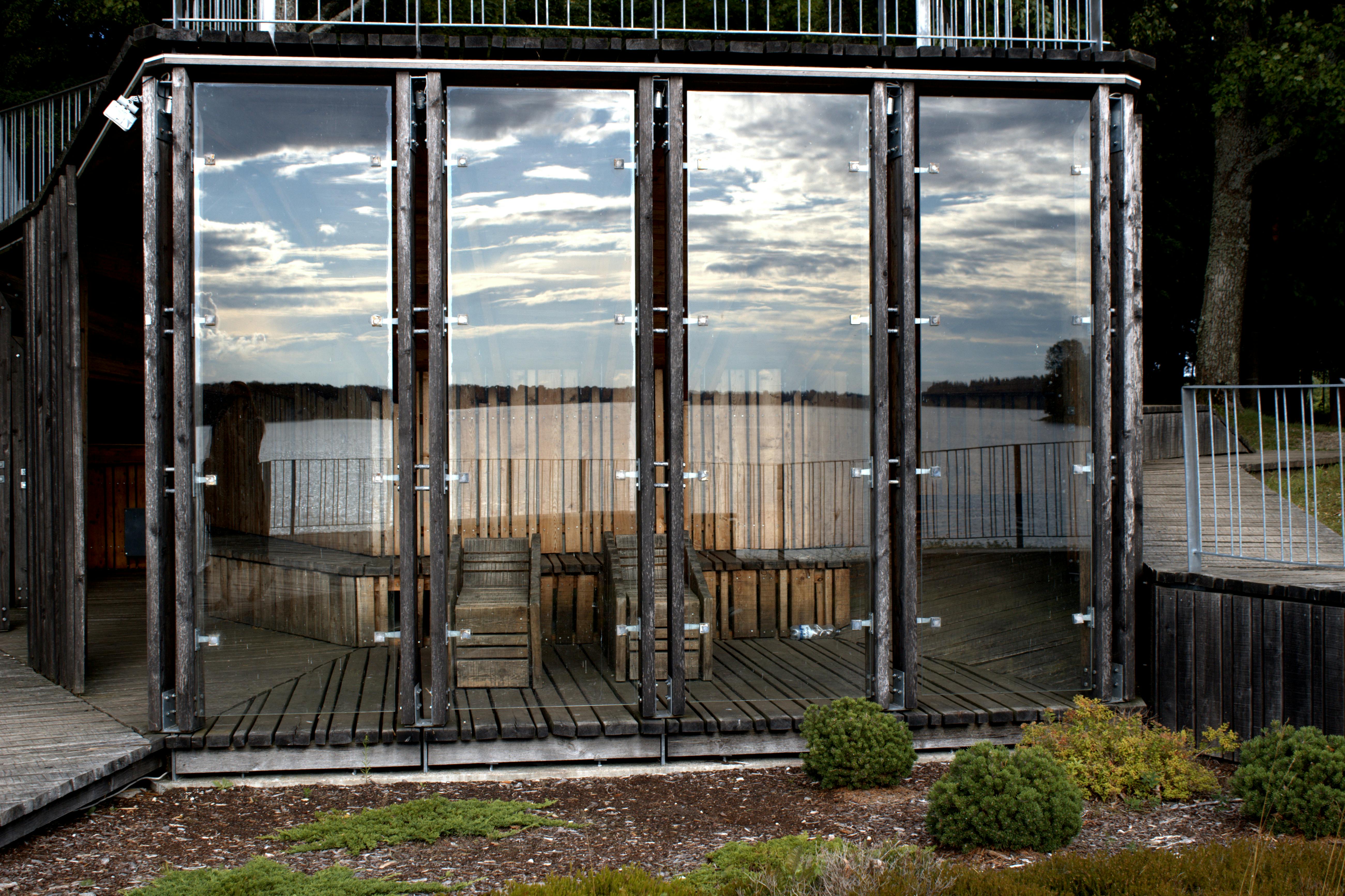 A glass walled building with a lake view · Free Stock Photo