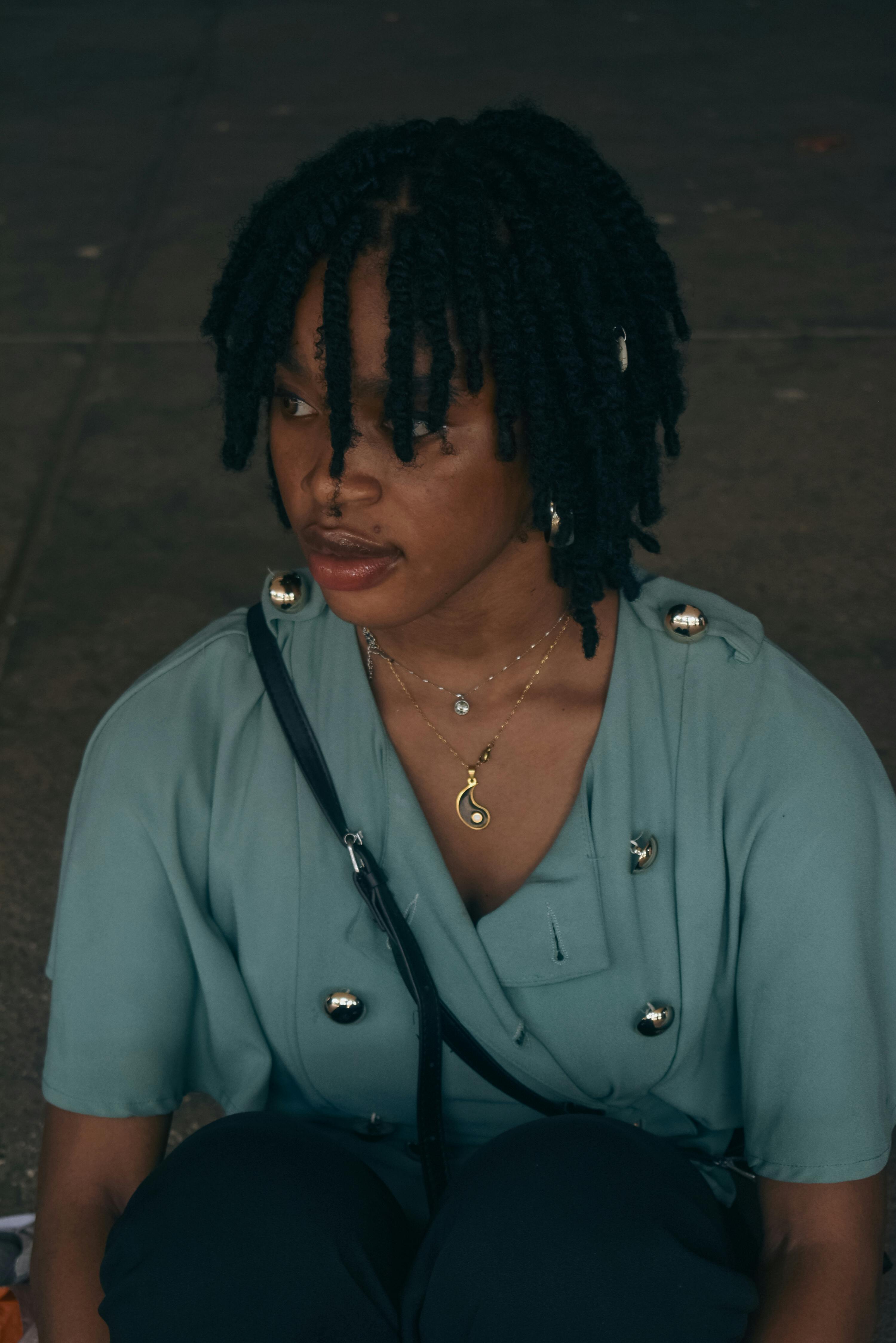 A woman with dreadlocks sitting on the ground · Free Stock Photo