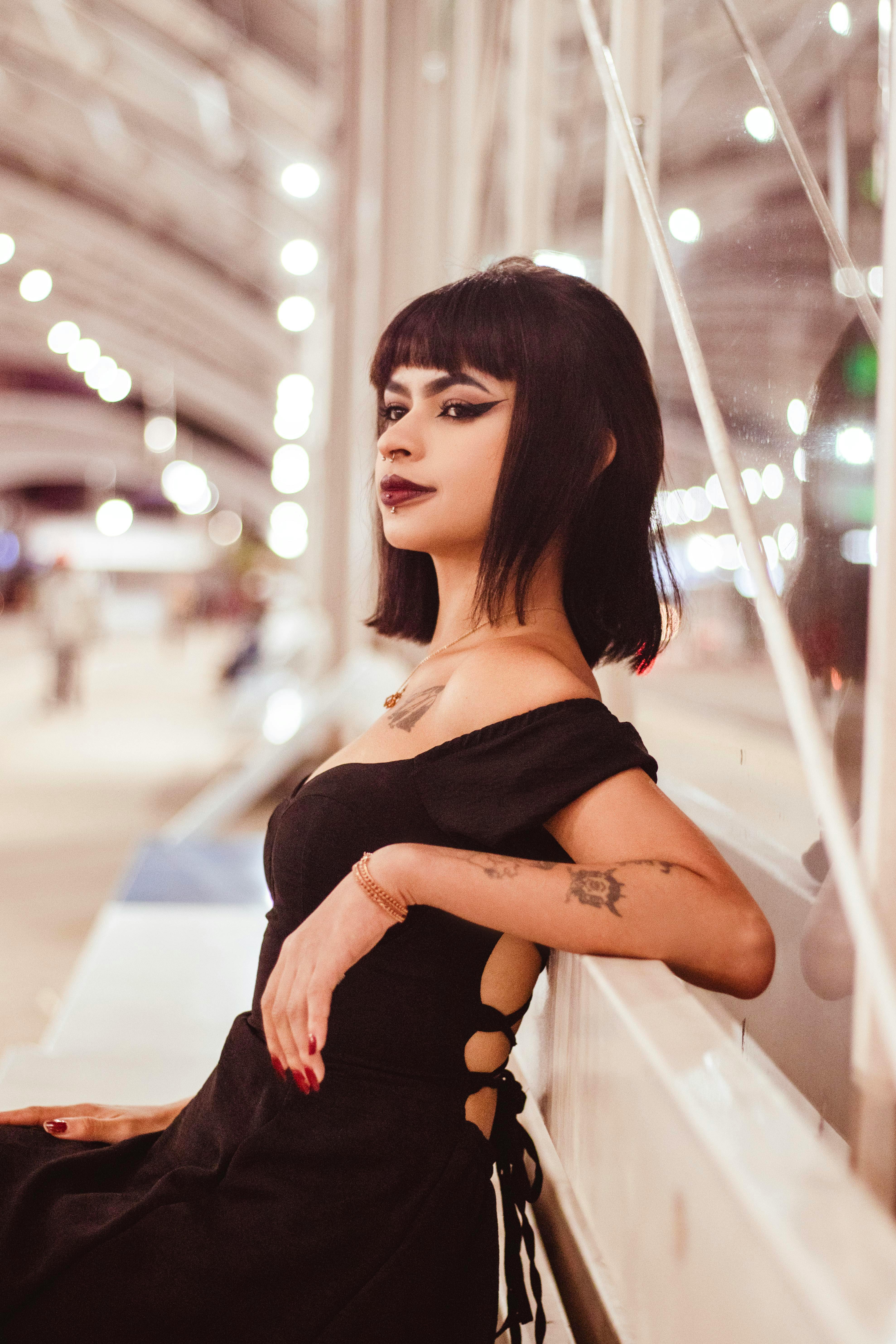 A woman with tattoos sitting on a bench · Free Stock Photo
