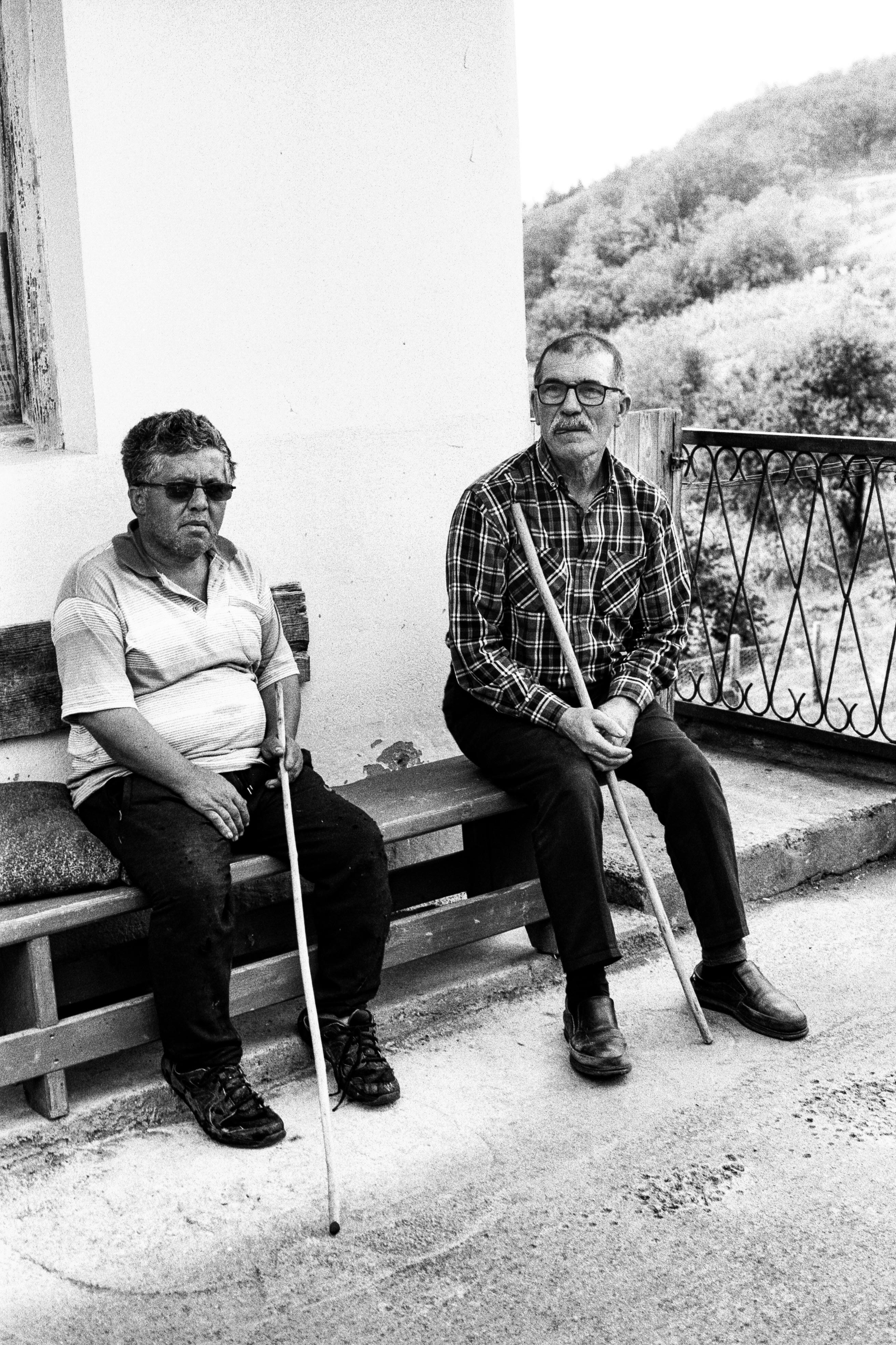Two men sitting on a bench with canes · Free Stock Photo