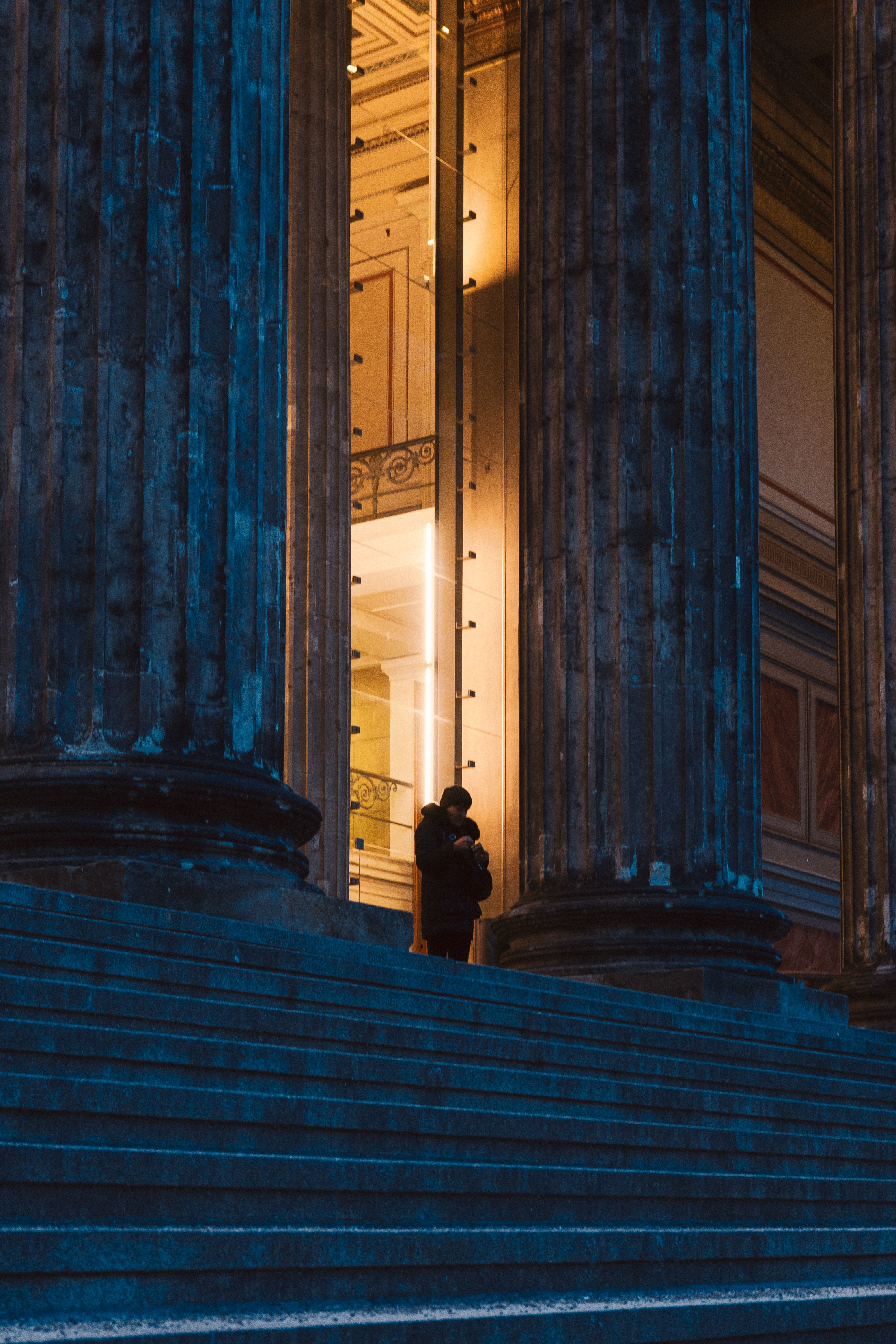 A man standing in front of some columns · Free Stock Photo