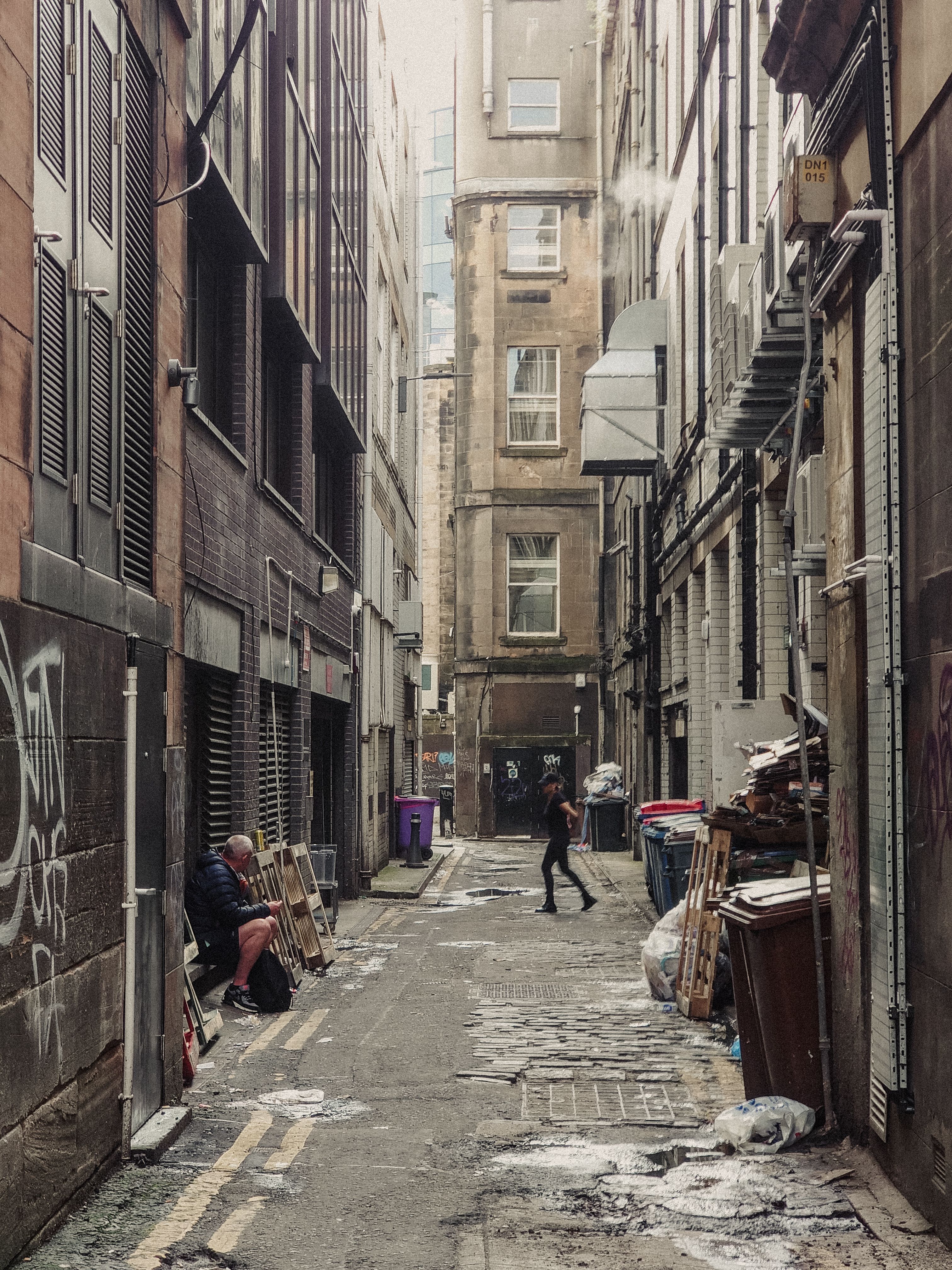 A person walking down a narrow alleyway in a city · Free Stock Photo