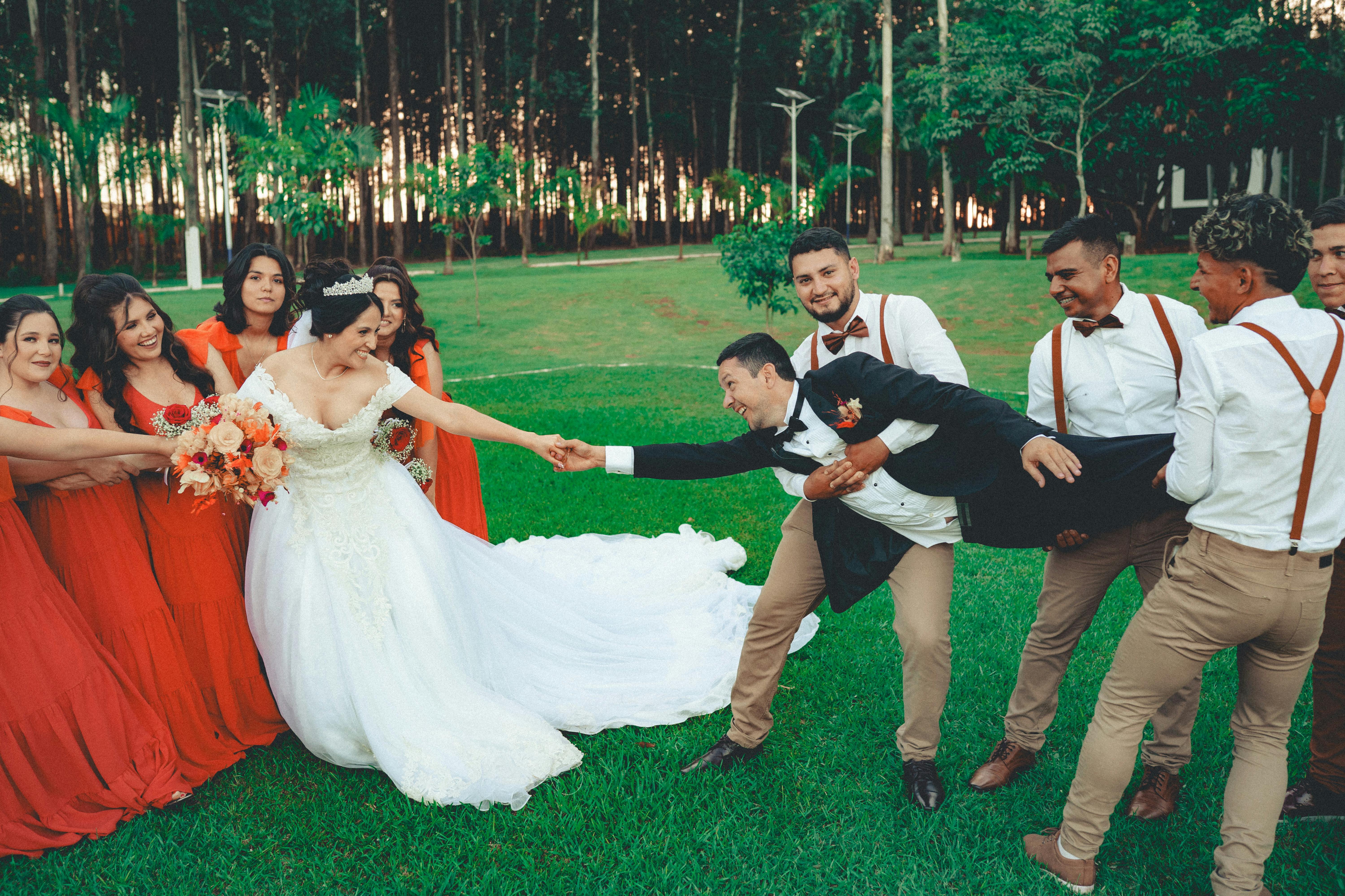 Bride and groom in red dresses and white suits · Free Stock Photo