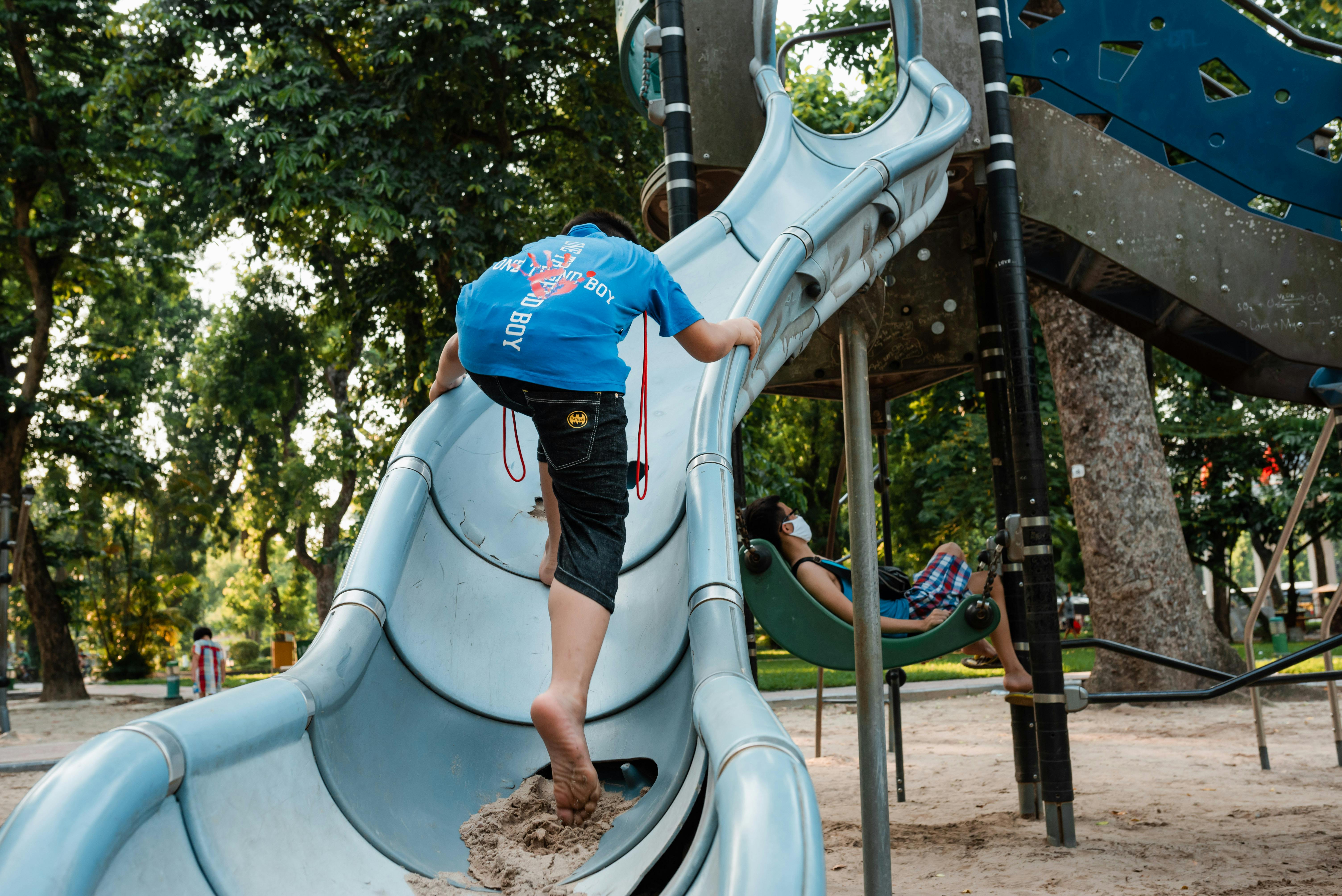 Boy Playing on Slide in Playground · Free Stock Photo