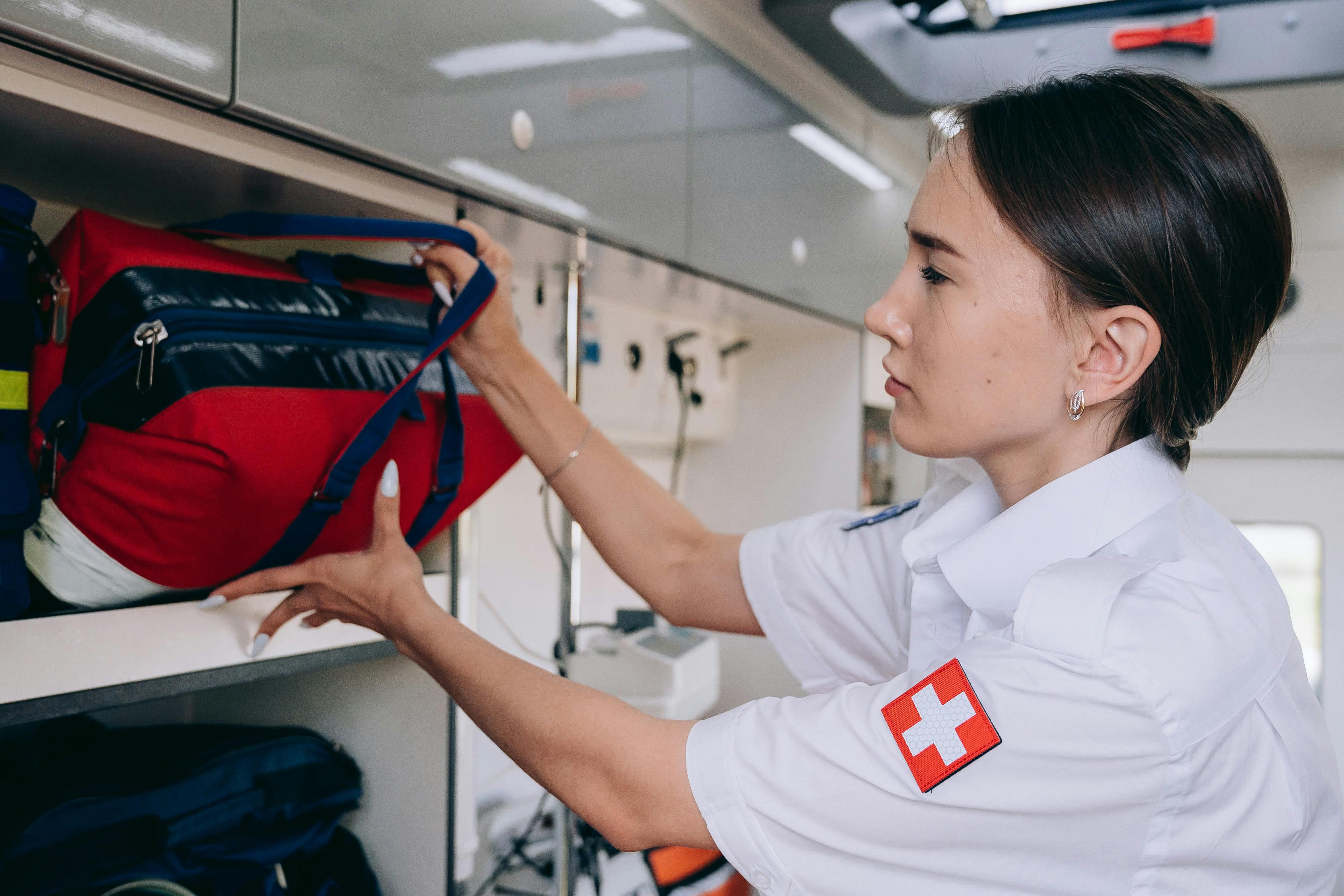 Paramedic Packing a Medical Bag Onto a Shelf in an Ambulance · Free ...
