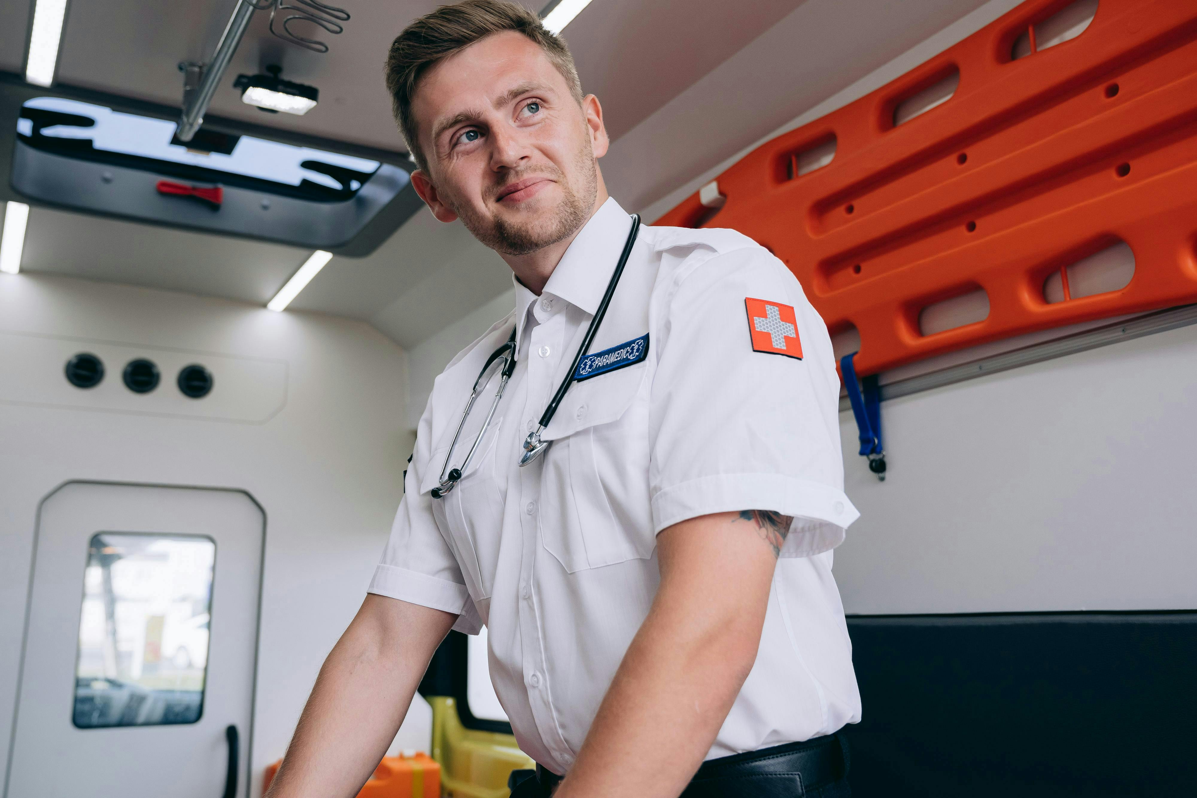 Smiling Paramedic Inside the Ambulance · Free Stock Photo