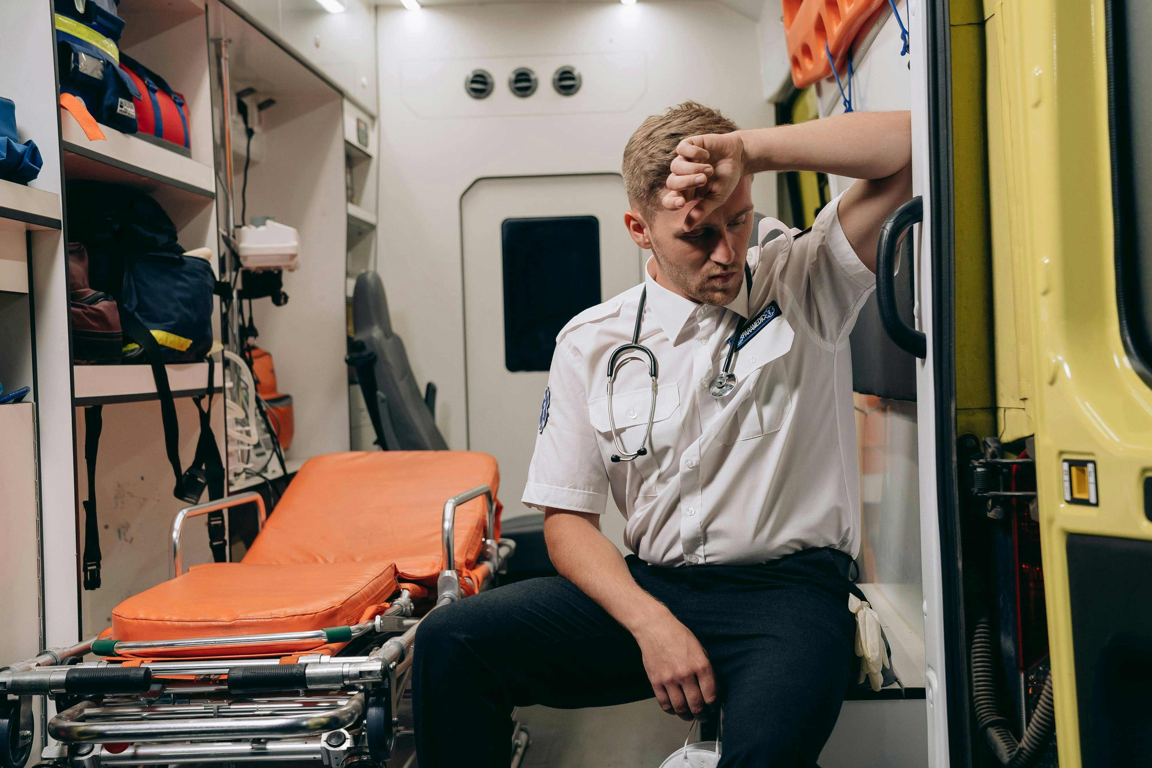 Tired Paramedic Sitting in Ambulance · Free Stock Photo