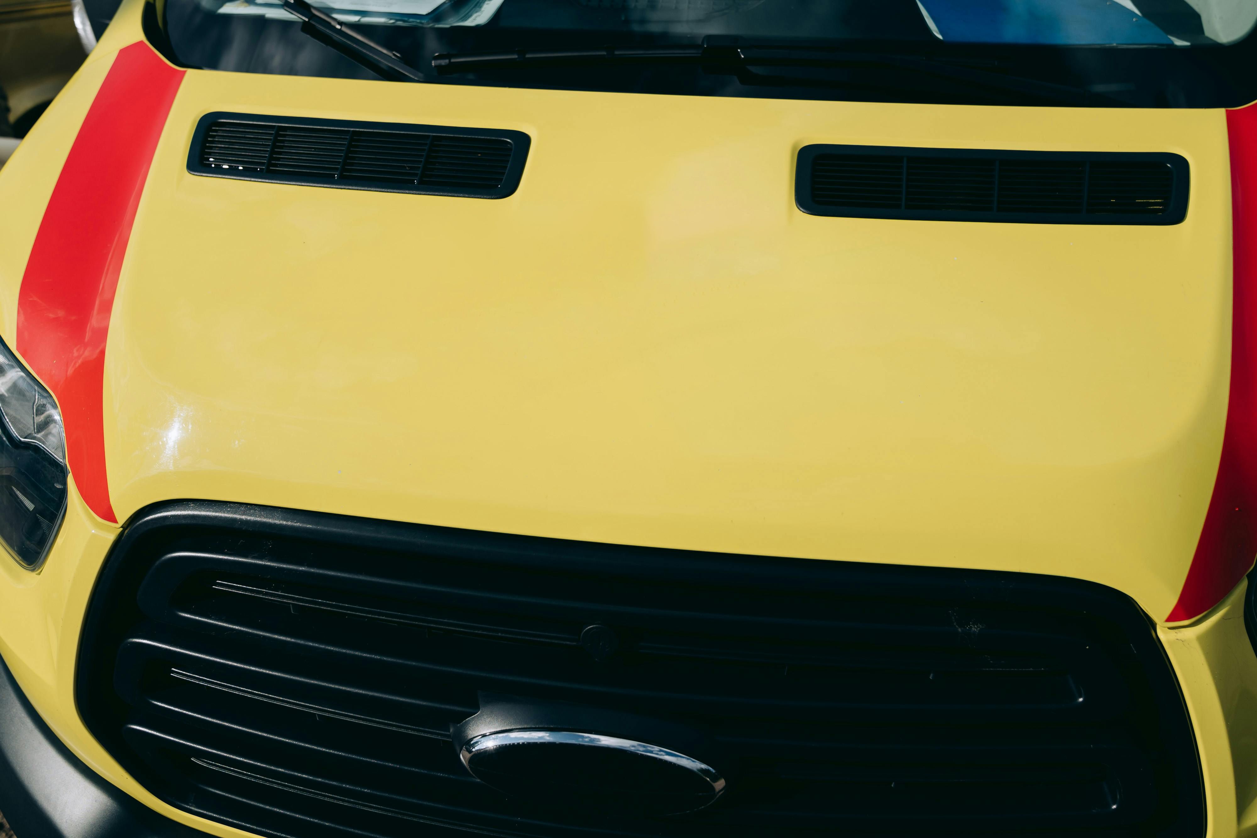 Hood and Grille of a Yellow Ambulance · Free Stock Photo