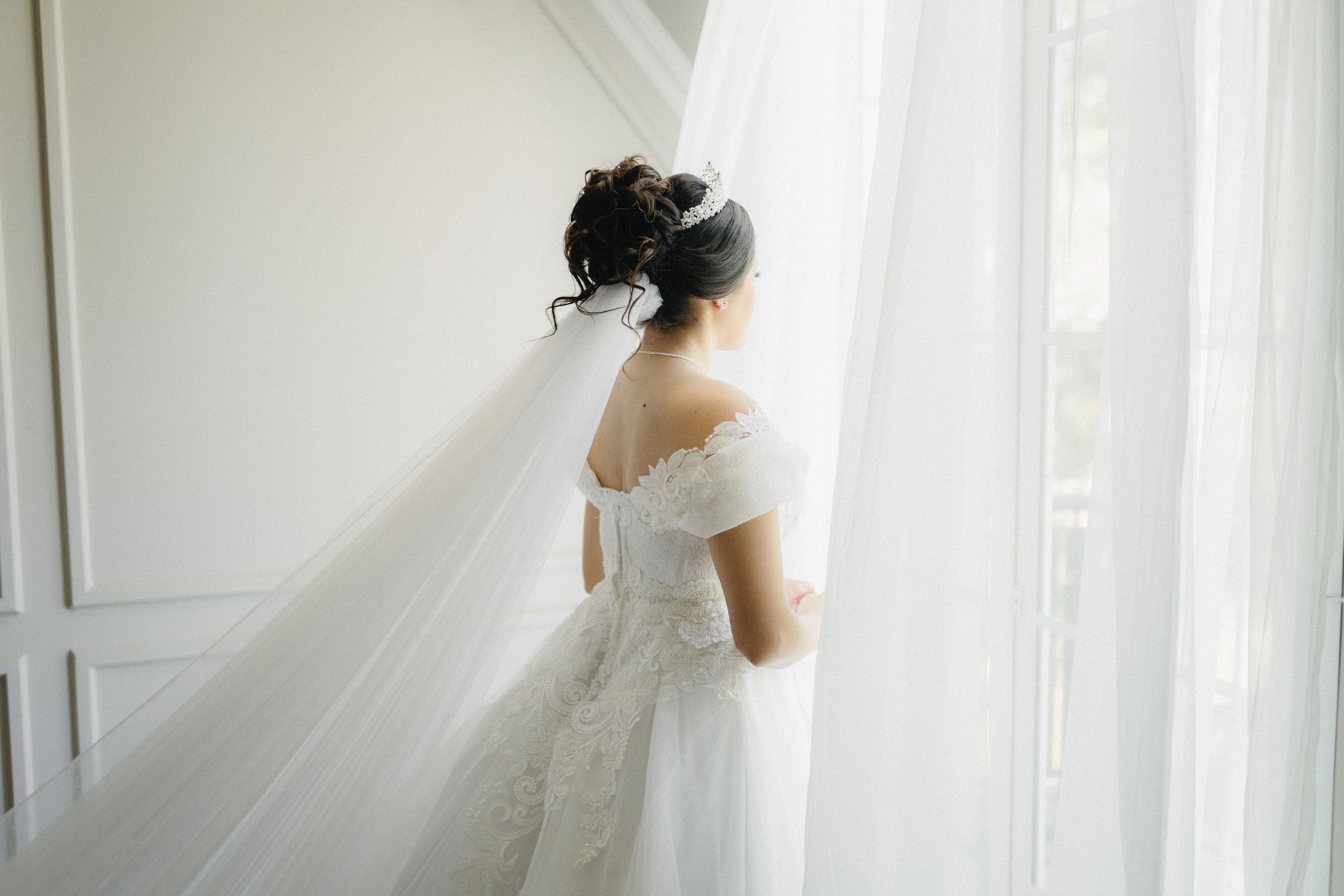 A bride looking out the window in her wedding dress · Free Stock Photo