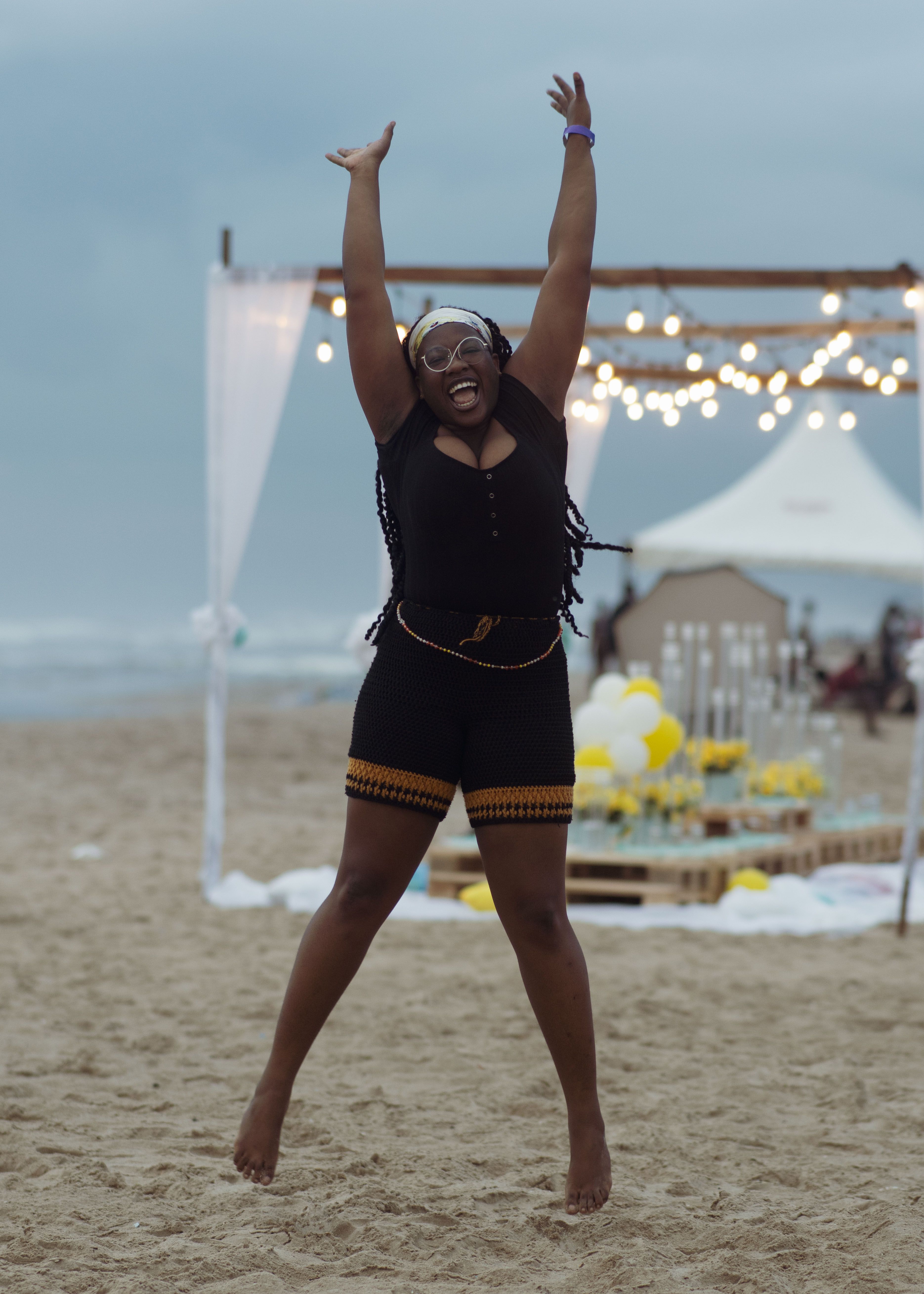 A woman jumping up in the air on the beach · Free Stock Photo