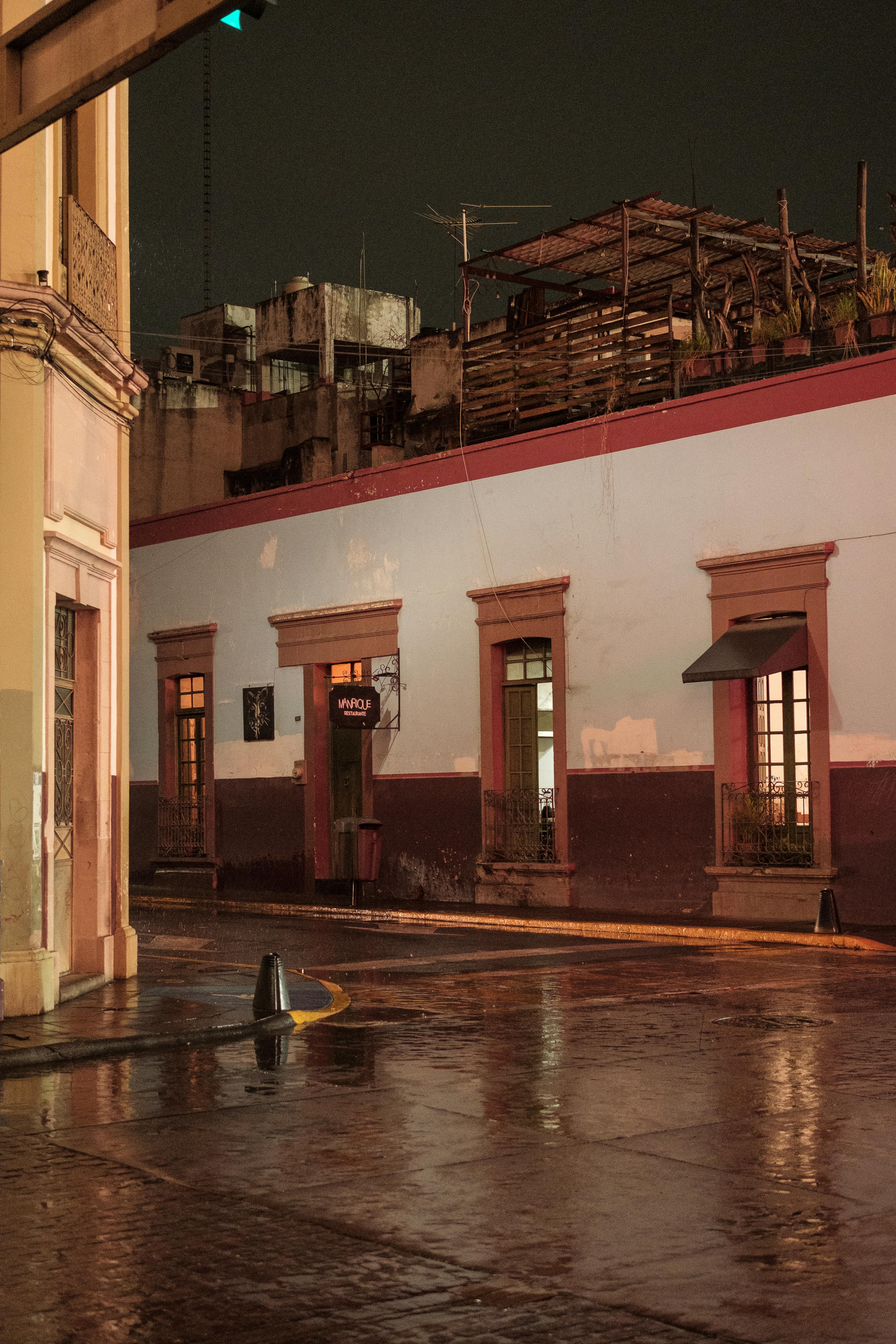 A rainy night scene with a street light and a building · Free Stock Photo